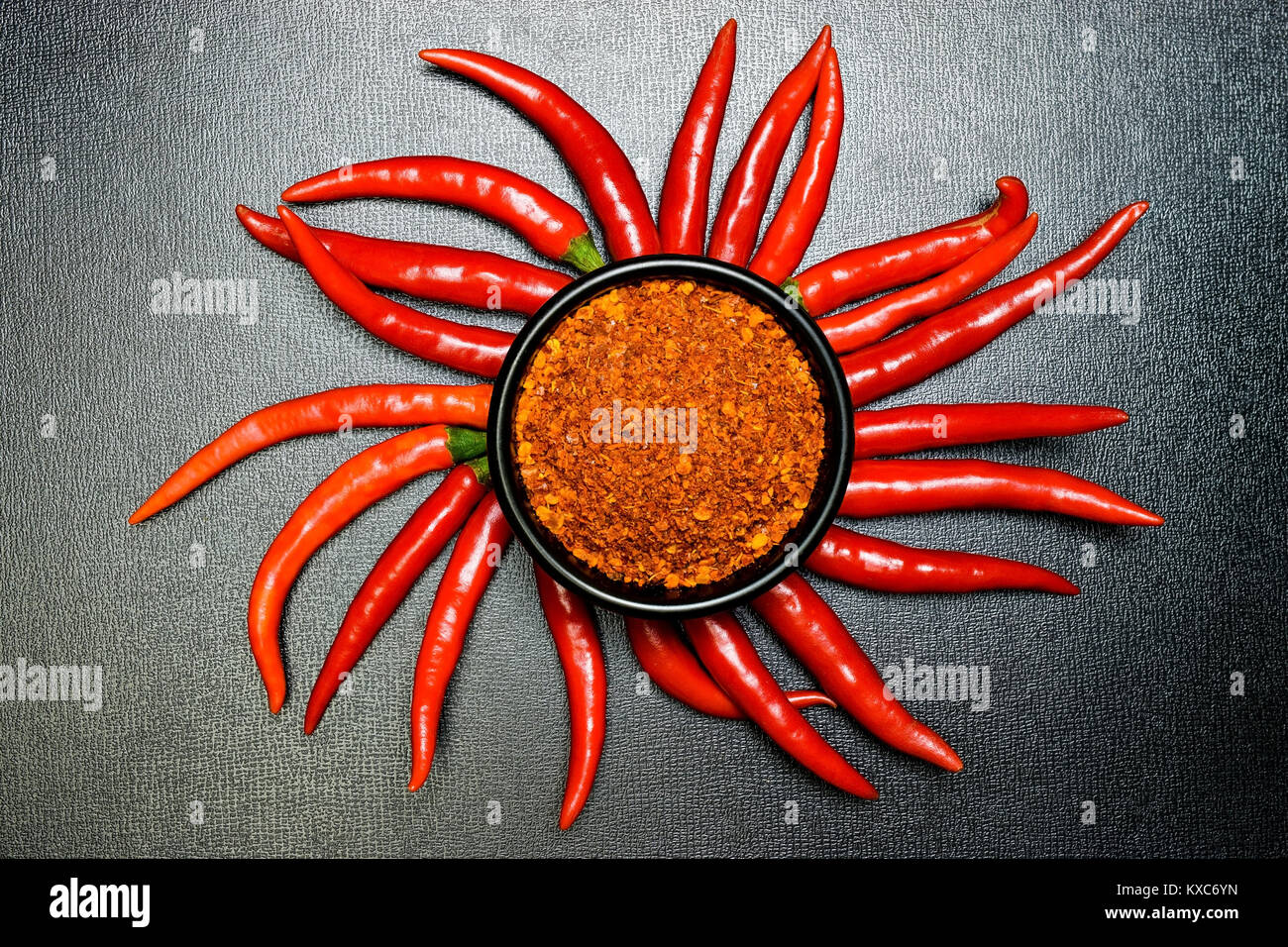 Hot red chili peppers and chili powder on a black background - top view ...