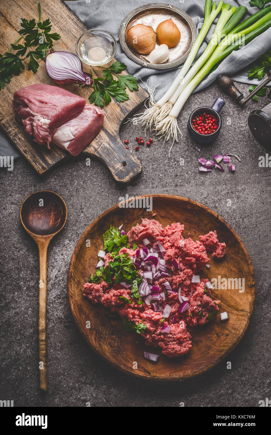 Ground meat in plate with cooking spoon with ingredients on rustic ...