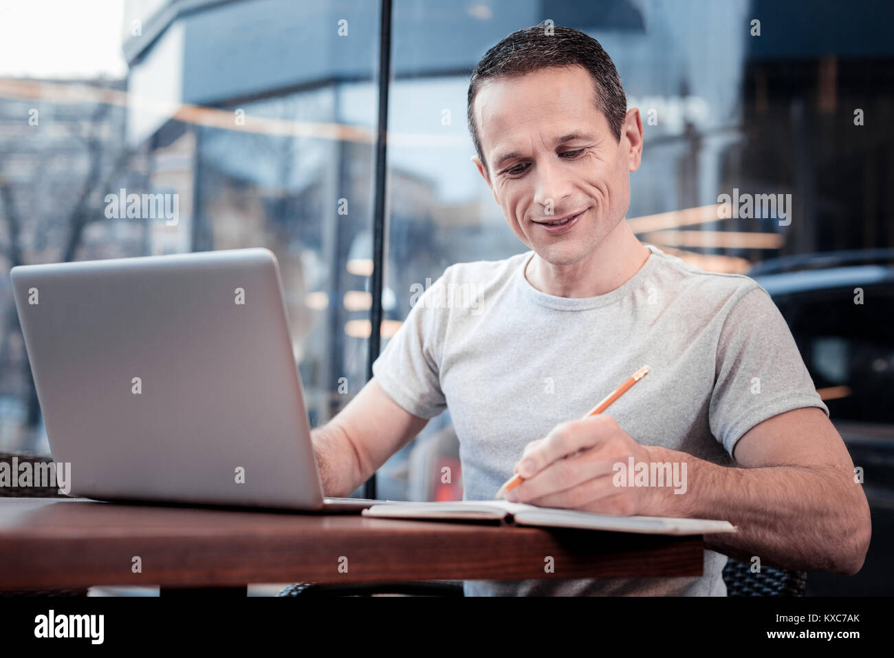 Concentrated young man making notes Stock Photo - Alamy