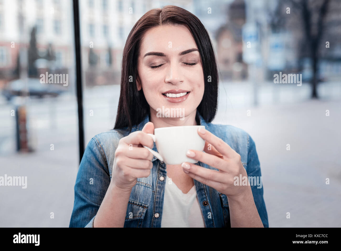 Positive delighted female person enjoying tasty coffee Stock Photo - Alamy