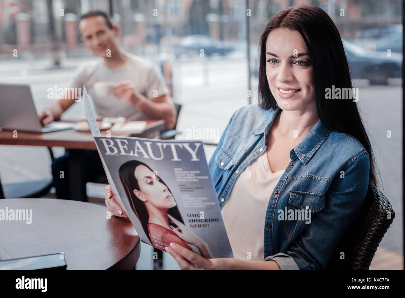 Attractive female person reading glossy magazine Stock Photo - Alamy