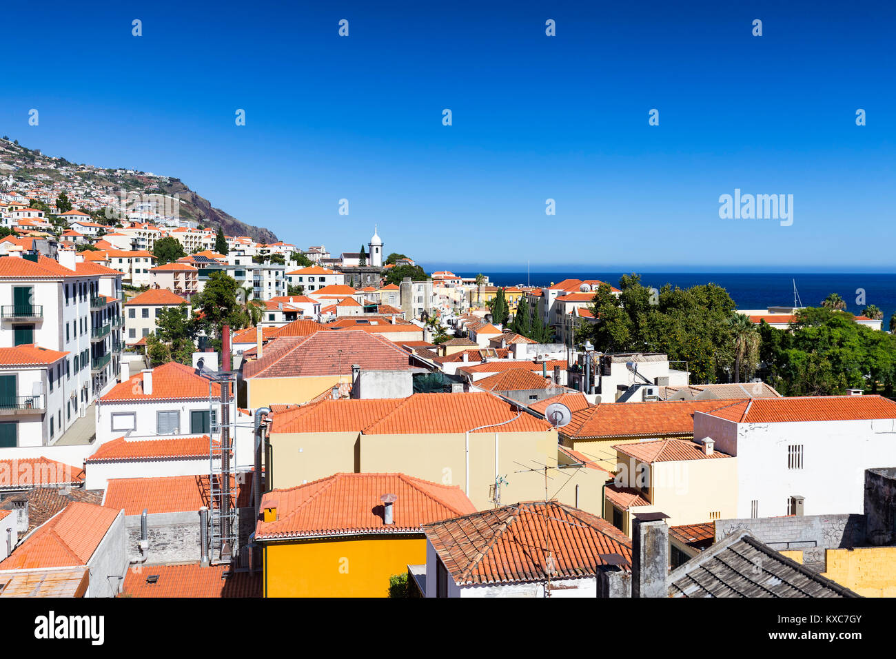 Aerial late afternoon view of of buildings and a church in Funchal ...