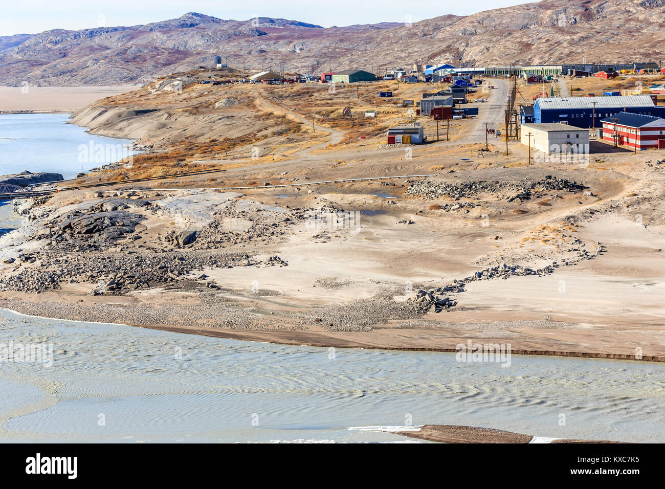 Living blocks standing in tundra on the hill above muddy melted glacier ...