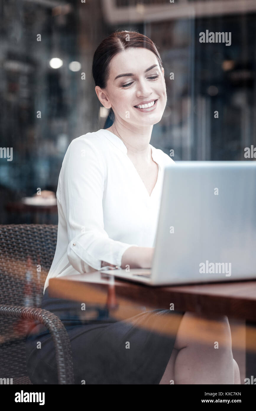 Cheerful lady looking at screen of her computer Stock Photo - Alamy
