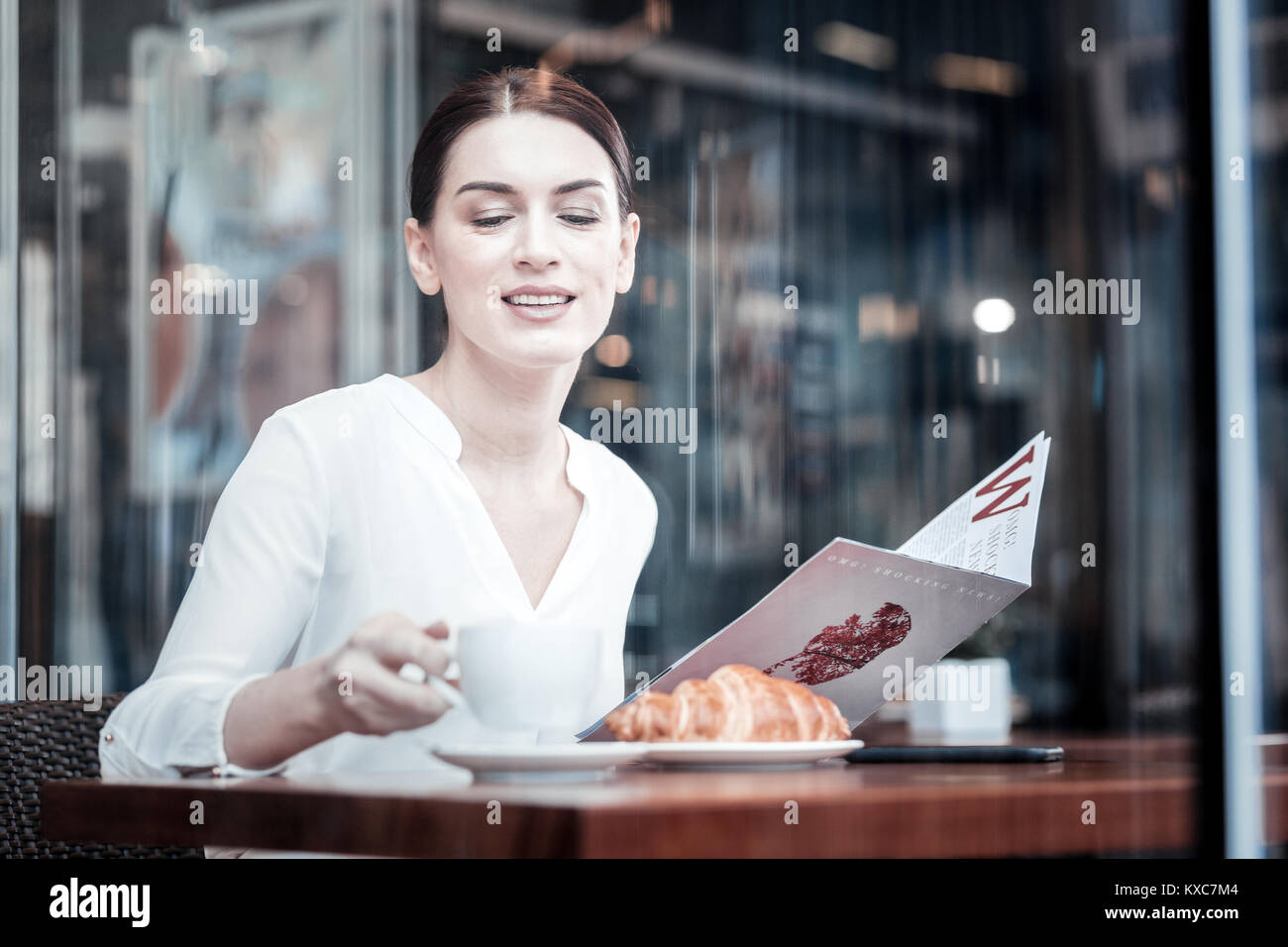 Concentrated young woman taking cup Stock Photo - Alamy