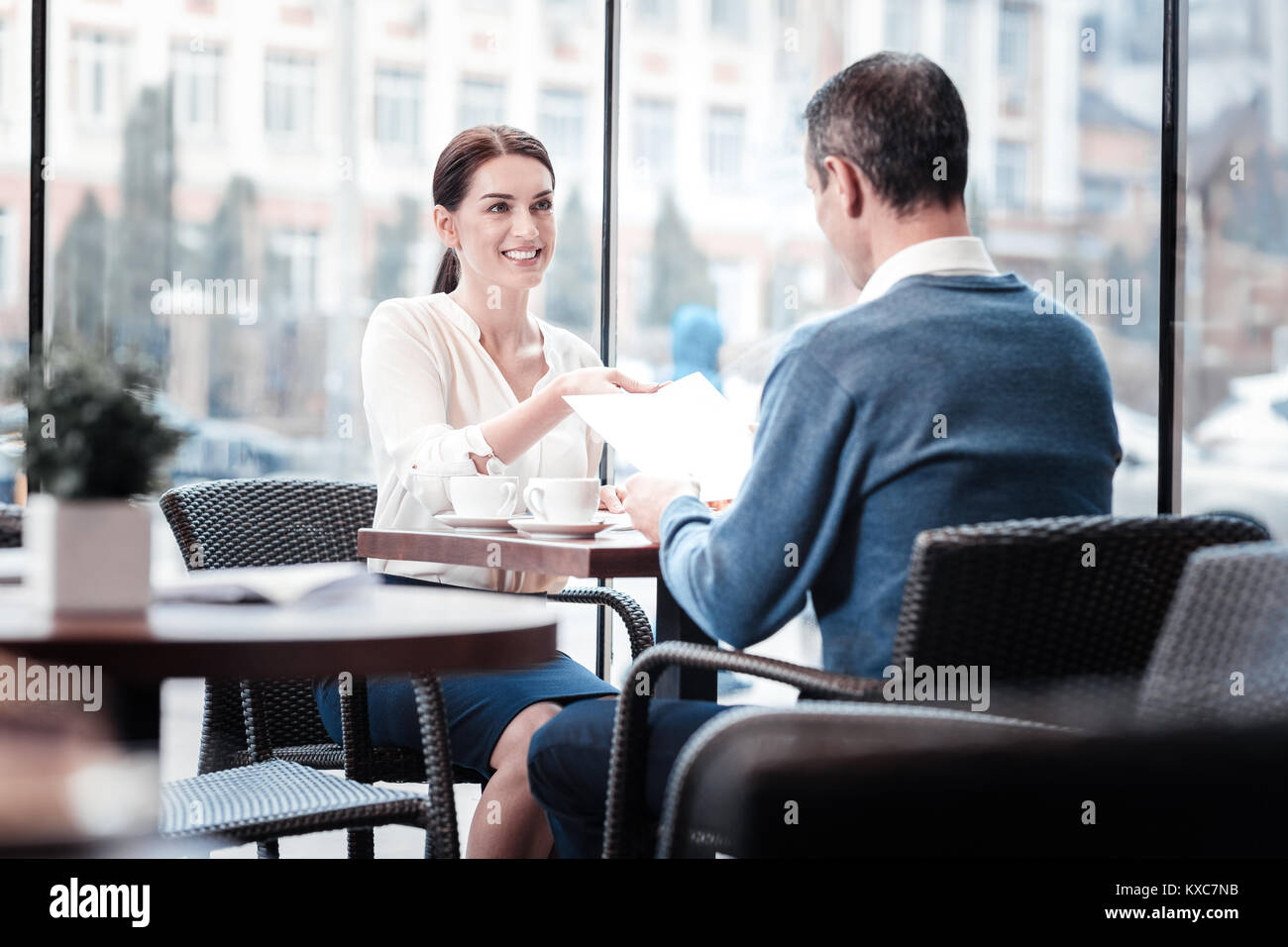 Pretty female person giving her CV Stock Photo - Alamy