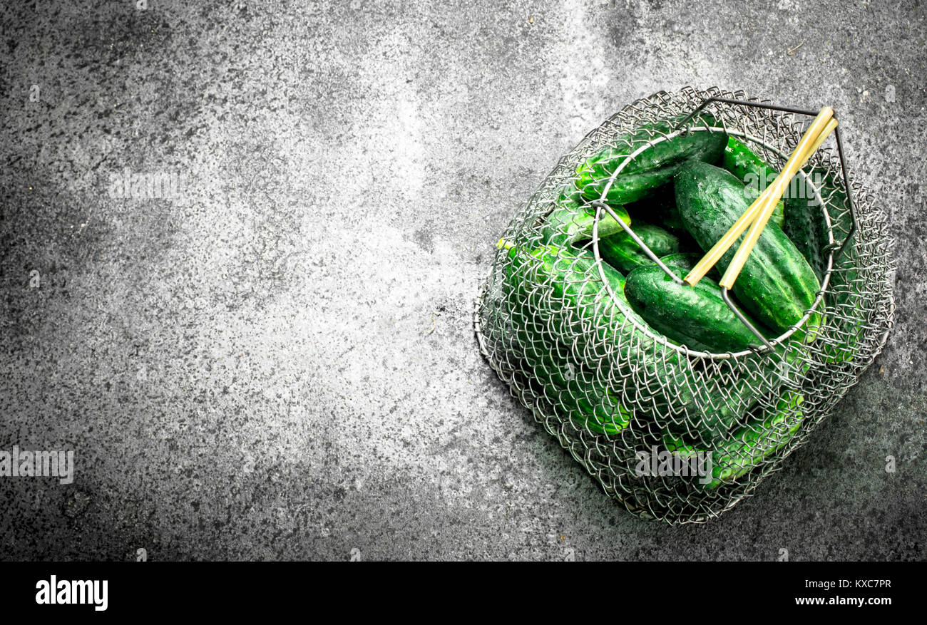 Fresh cucumbers in a mesh bag. On a rustic background Stock Photo - Alamy