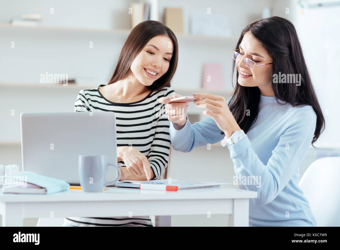 Optimistic female colleagues taking photo of documentation Stock Photo ...