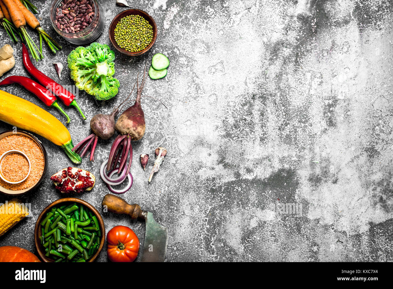 Organic food. Legumes with fresh vegetables. On a rustic background ...