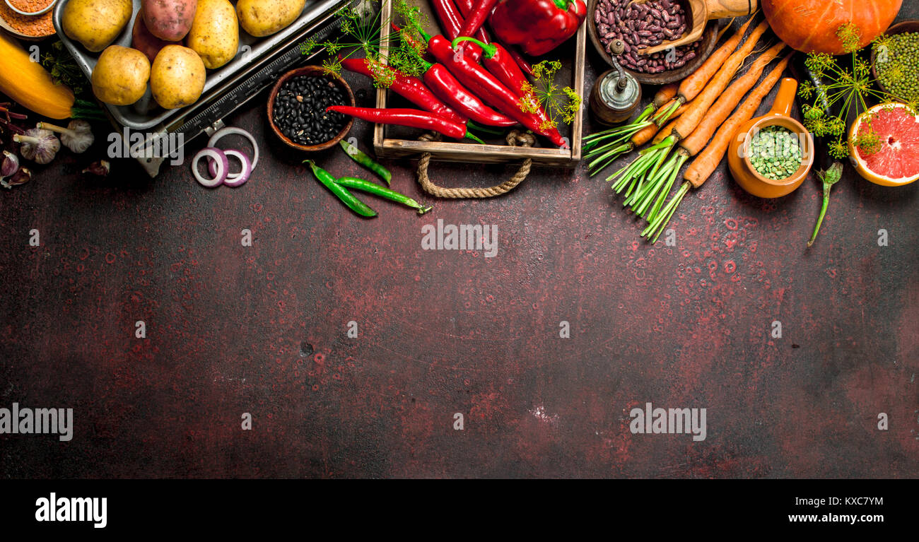 Organic food. Fresh crop of legumes and vegetables. On a rustic ...