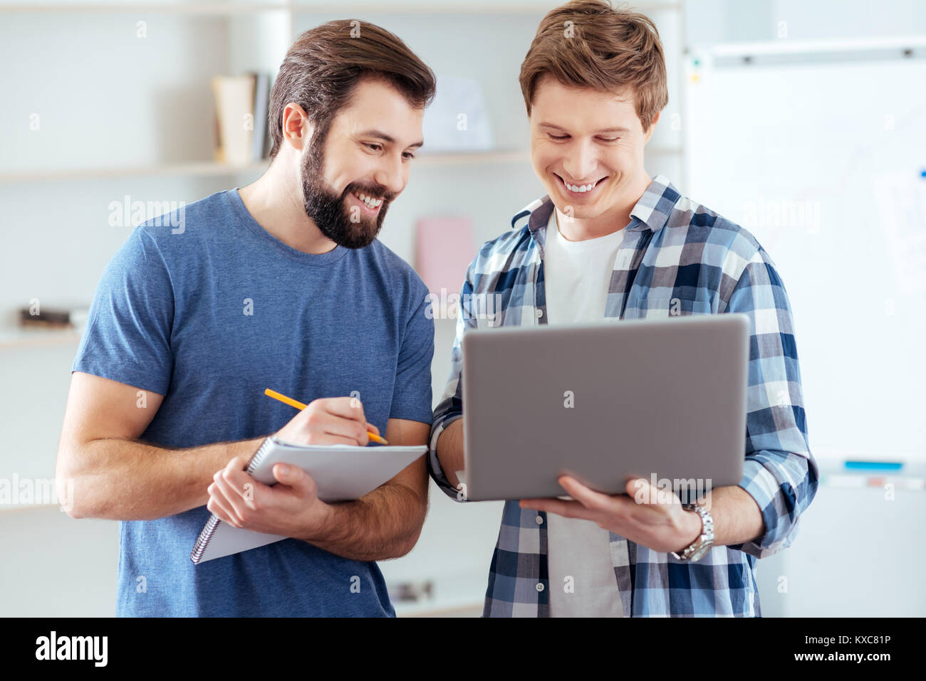 Appealing male colleagues distracting from work Stock Photo - Alamy