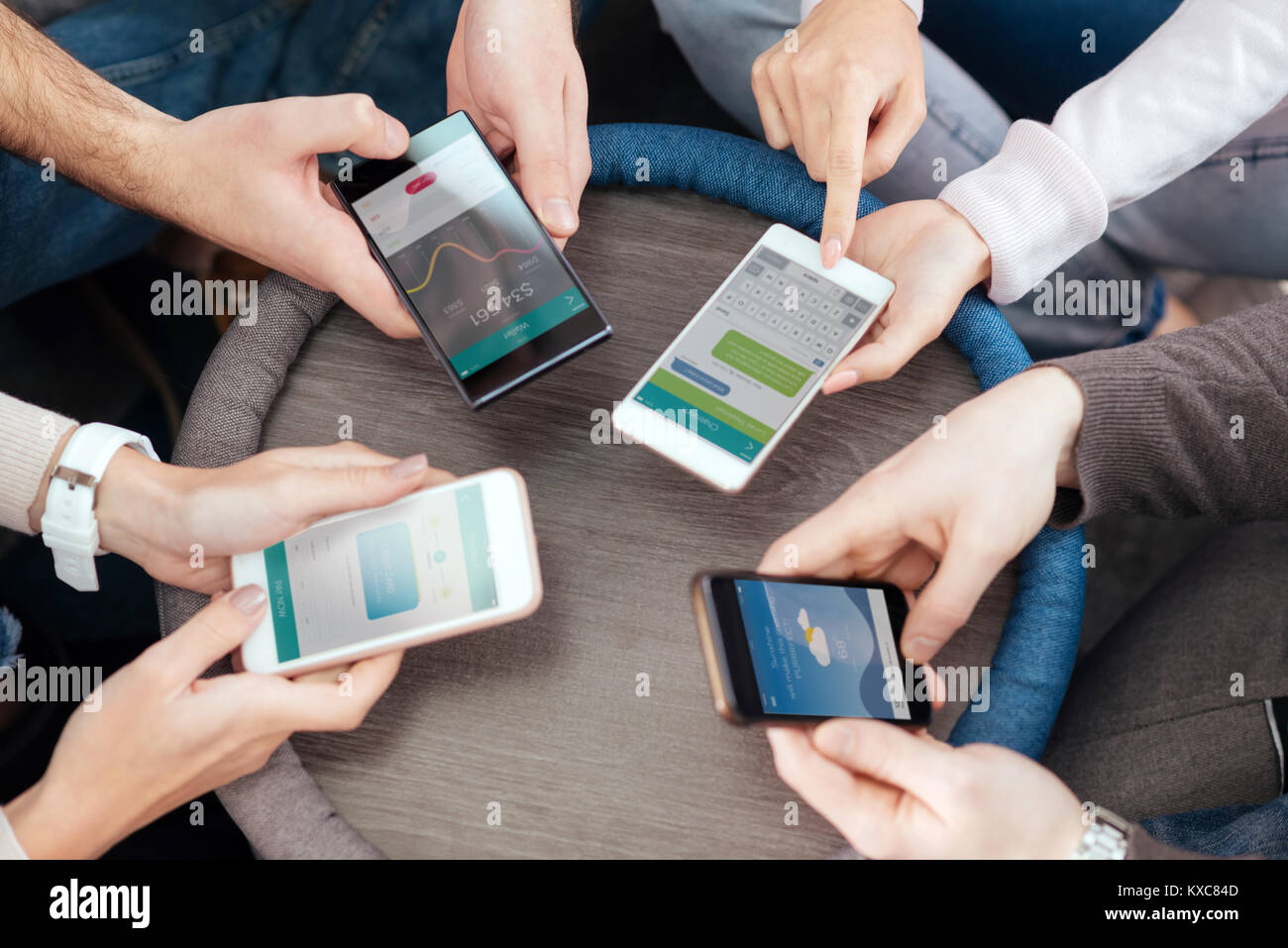 Four pair of hands holding phones Stock Photo - Alamy