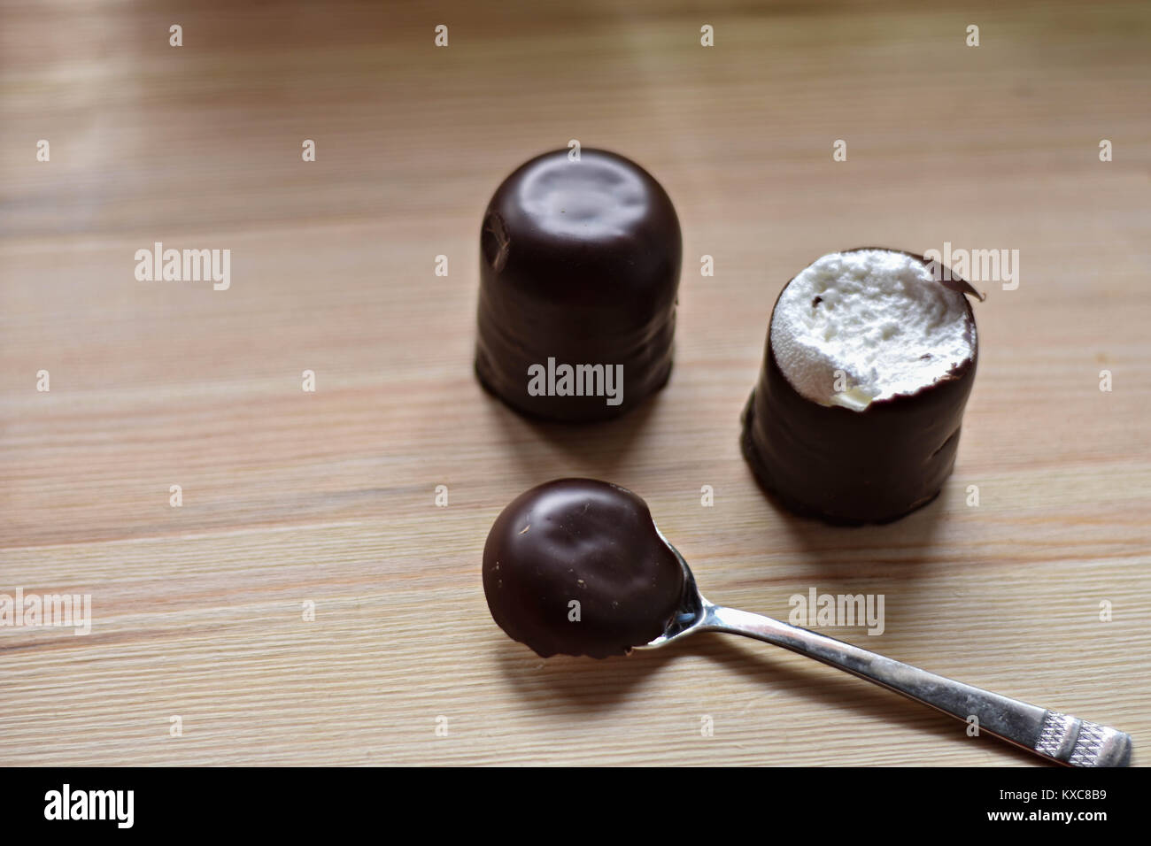 chocolate marsh-mallow whit silver spoon on light wooden background ...