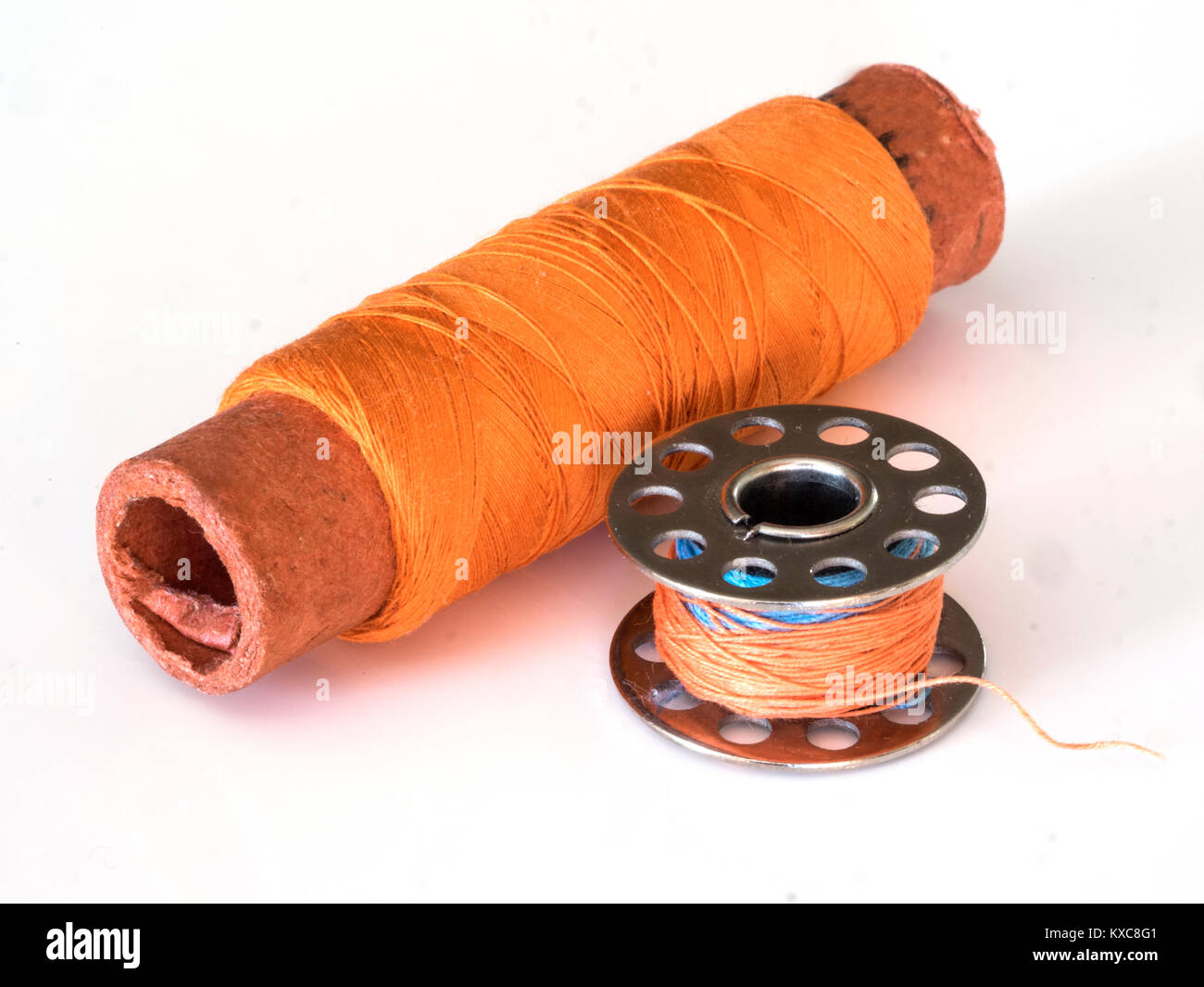 vintage coil with orange thread and bobbin from sewing machine isolated ...