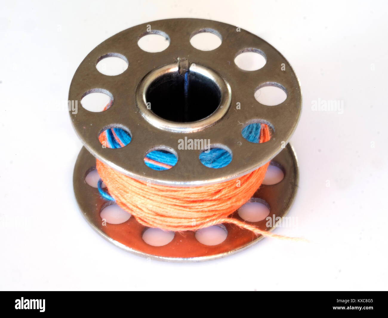 vintage bobbin from sewing machine with orange threadisolated on white ...