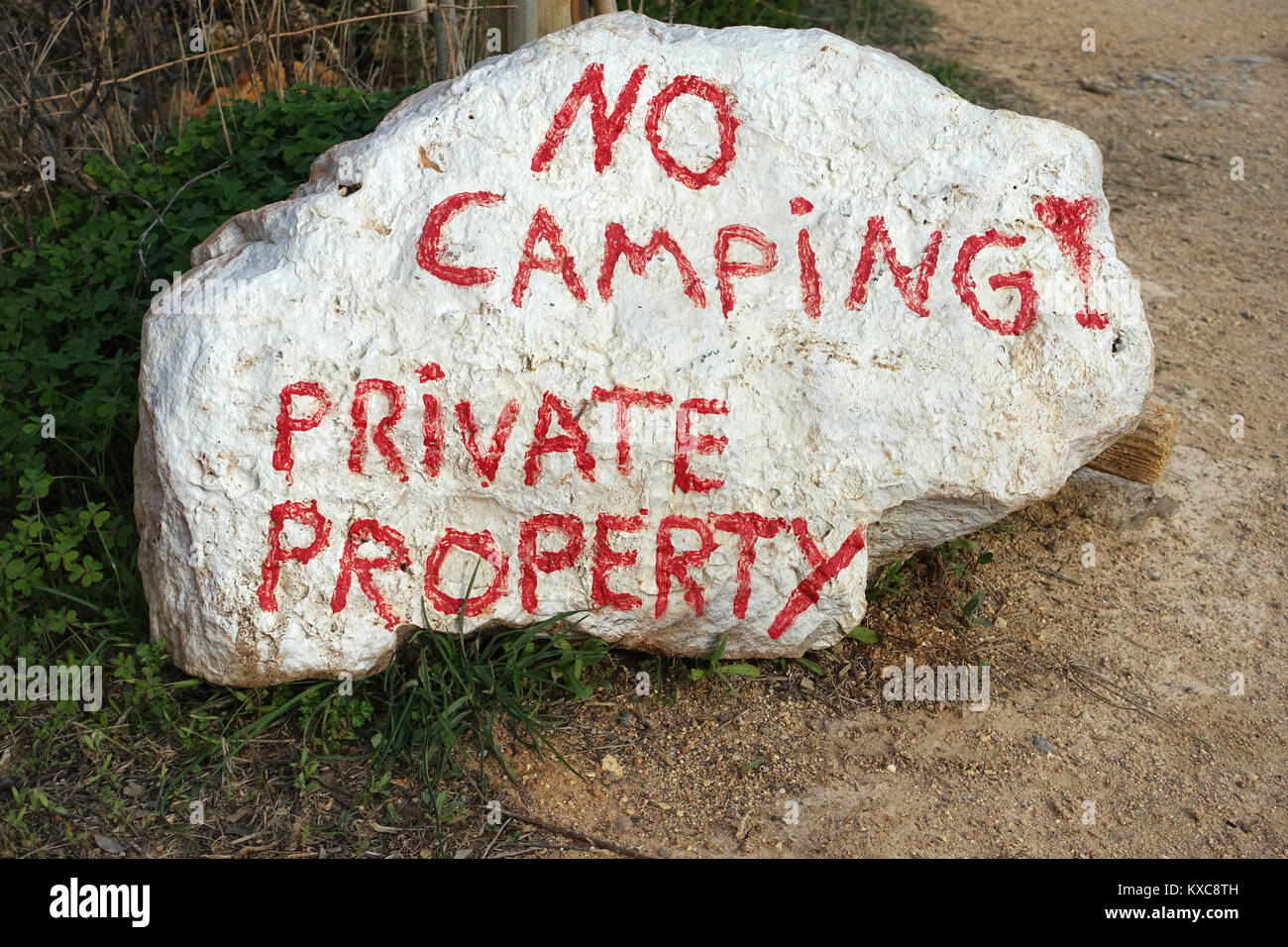 Private Property sign written in red on large white rock Stock Photo ...