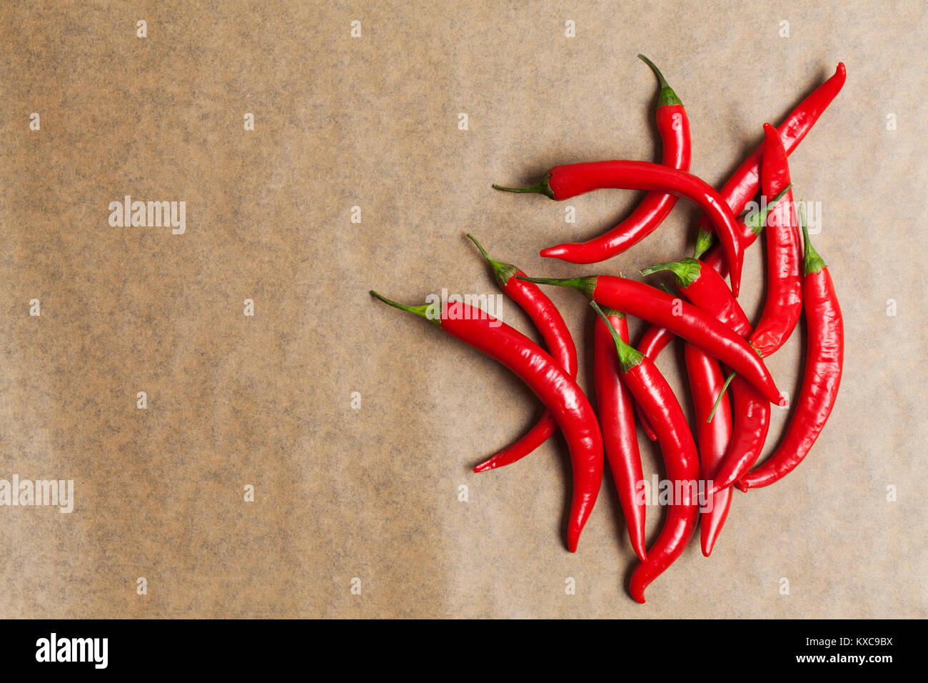 Red fresh chili peppers on a brown paper background Stock Photo - Alamy