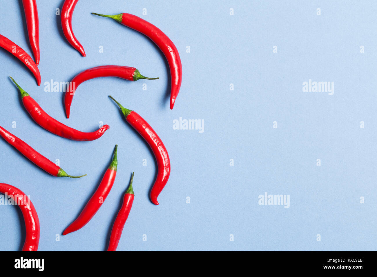 Red chili peppers arranged on a light blue background Stock Photo - Alamy