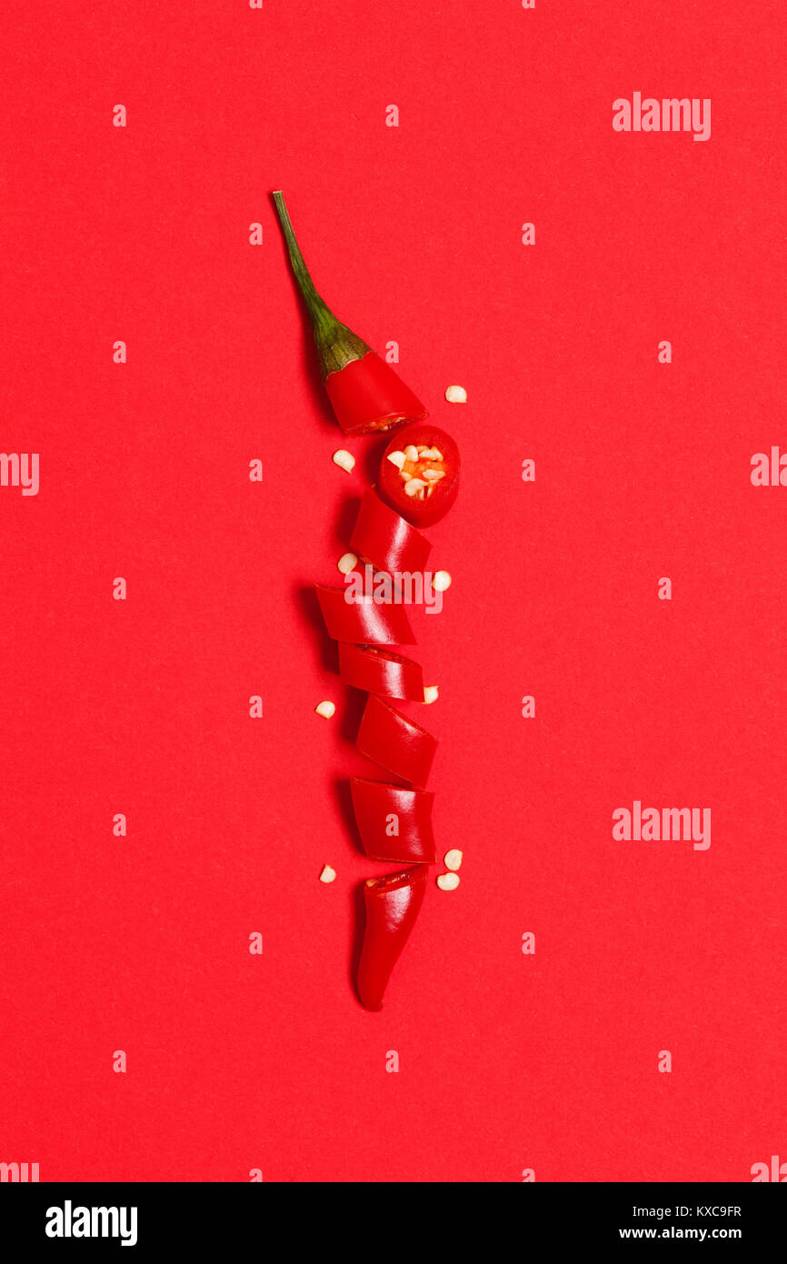 Sliced red chili pepper arranged on a bright red background Stock Photo ...