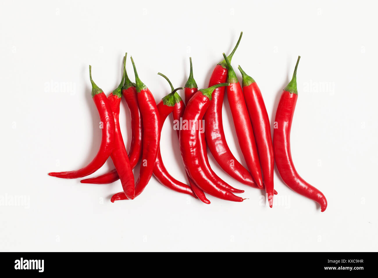 Red fresh chili peppers on a plain white background Stock Photo - Alamy