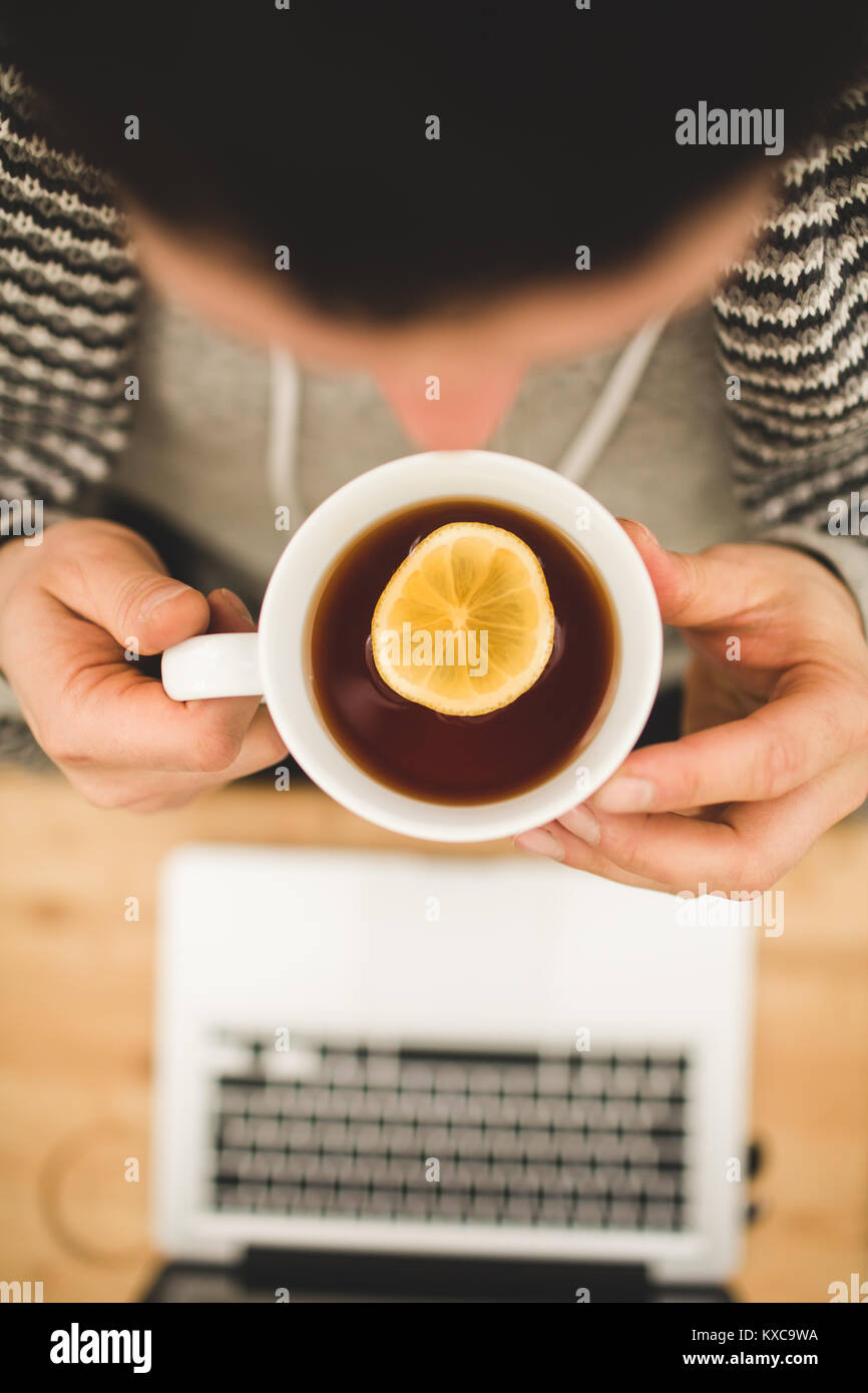 Top view hands with cup of tea with lemon and laptop Stock Photo - Alamy