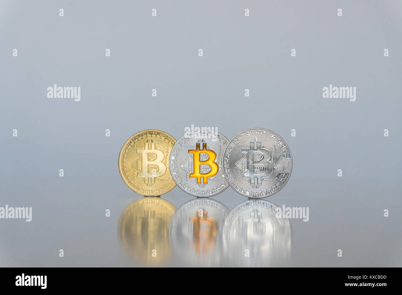 A set of bitcoins. Platinum, silver and gold coins isolated on a light ...