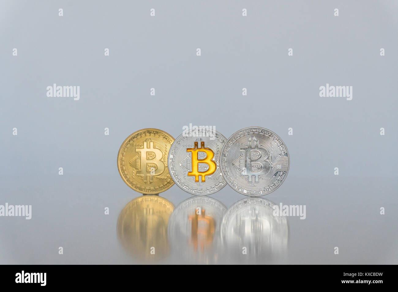 A set of bitcoins. Platinum, silver and gold coins isolated on a light ...