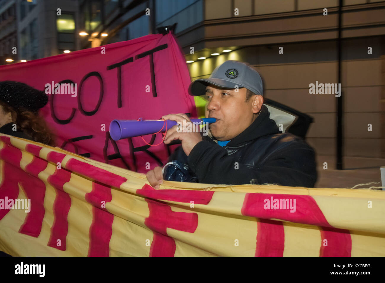 A cleaner blows a plastic horn in the United Voices of the Word protest ...