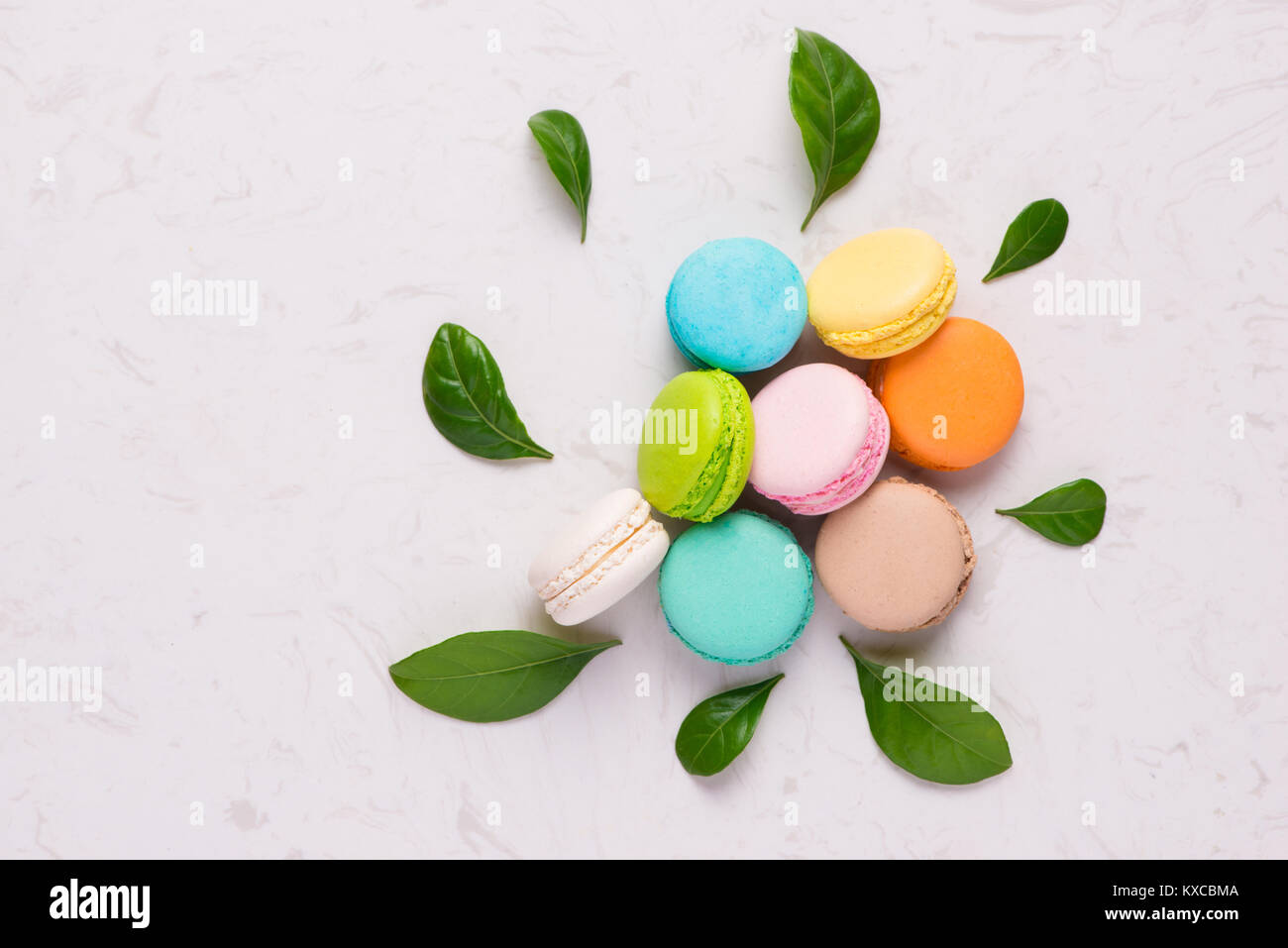 Spring concept with macaroons and green leaves. Top view Stock Photo ...