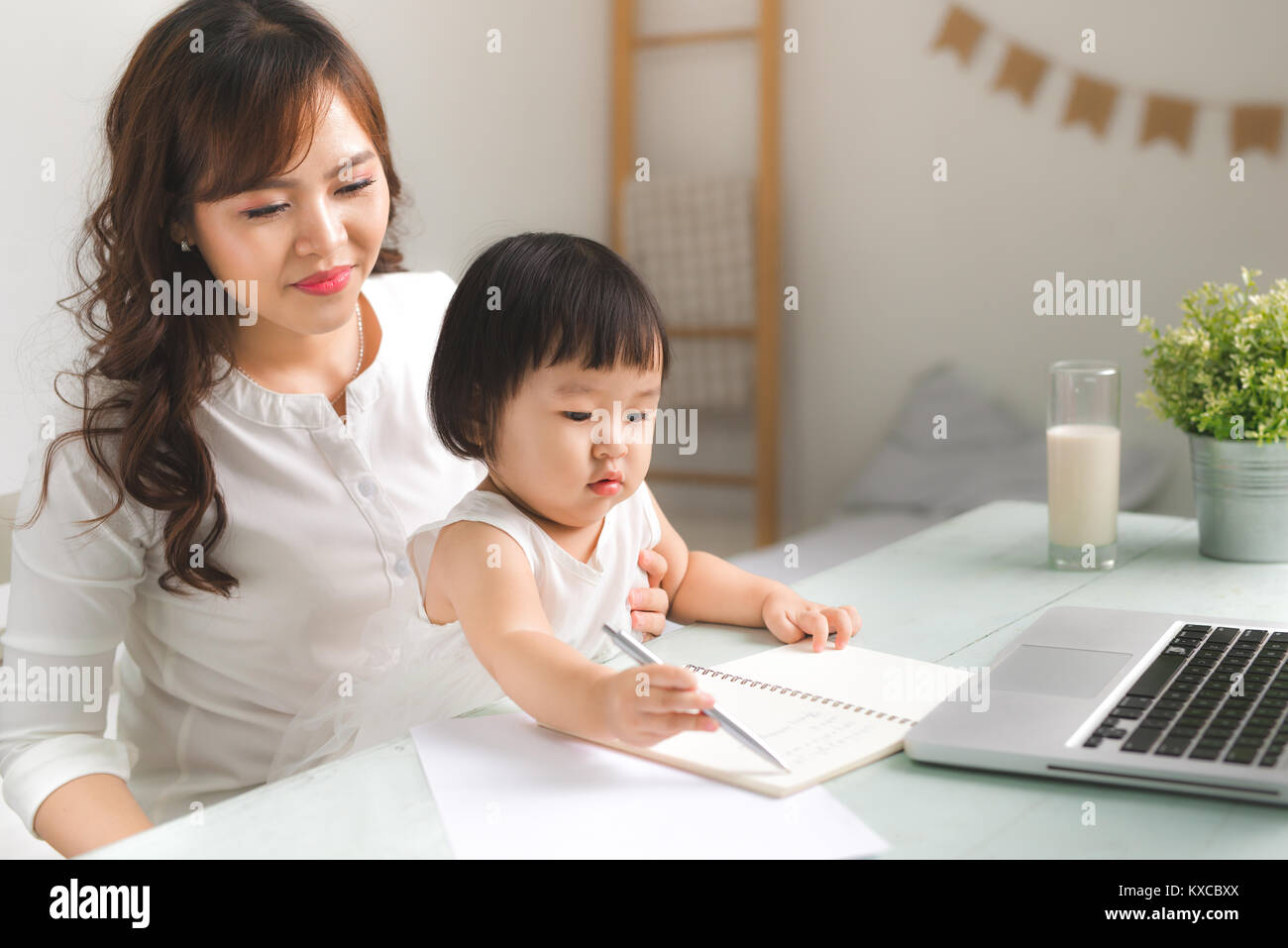 Mother and daughter are learning to write Stock Photo - Alamy