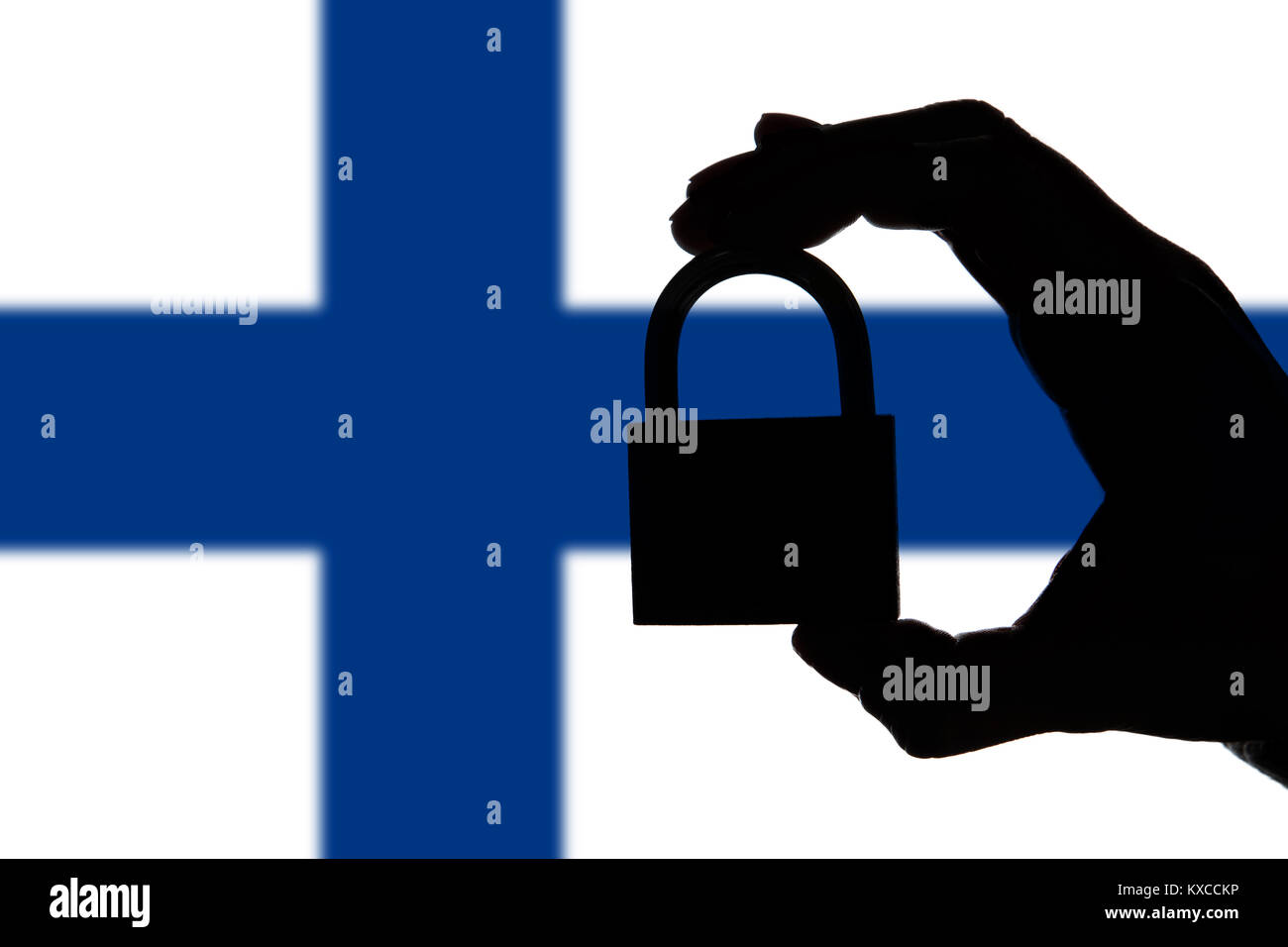 Finland security. Silhouette of hand holding a padlock over national ...