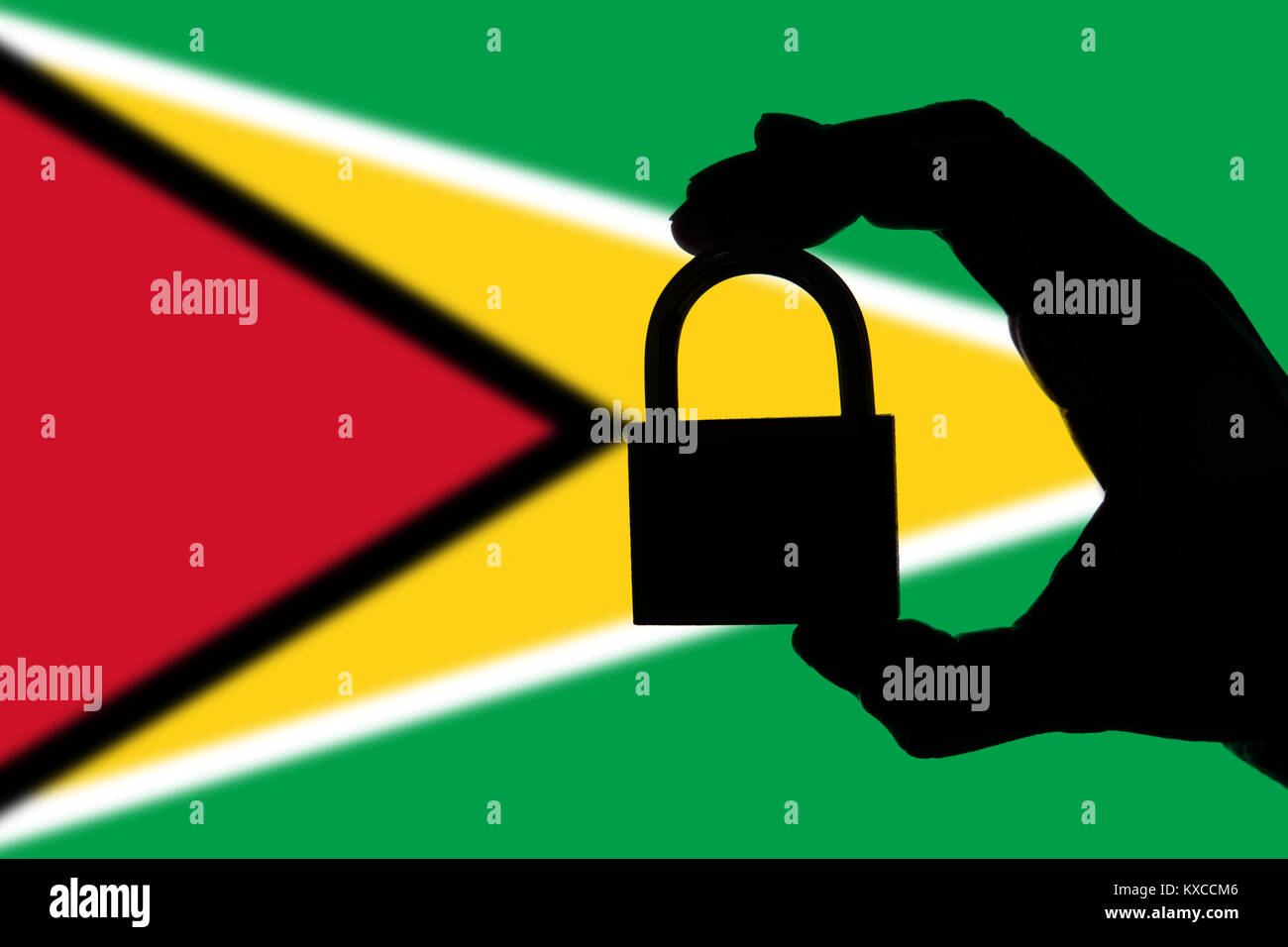 Guyana security. Silhouette of hand holding a padlock over national ...