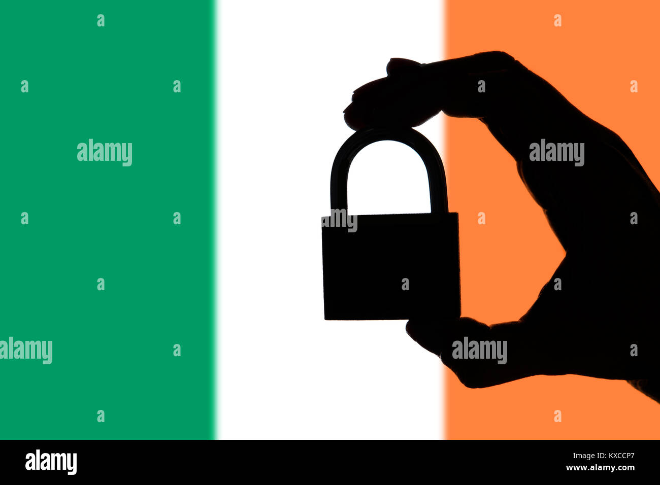 Ireland security. Silhouette of hand holding a padlock over national ...