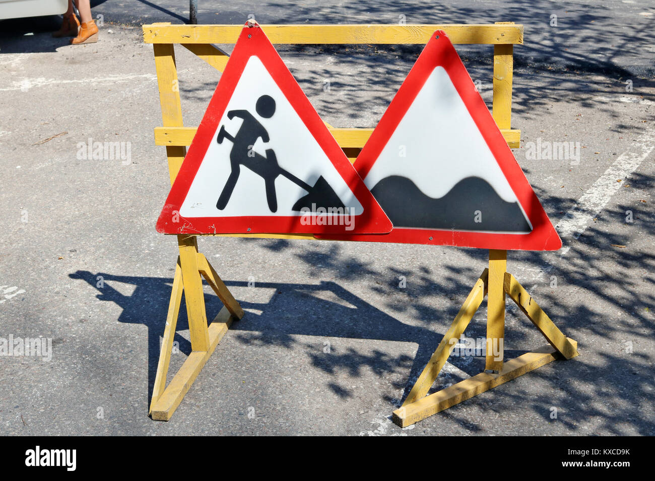 Curved ugly warning road signs are installed on the road being repaired ...