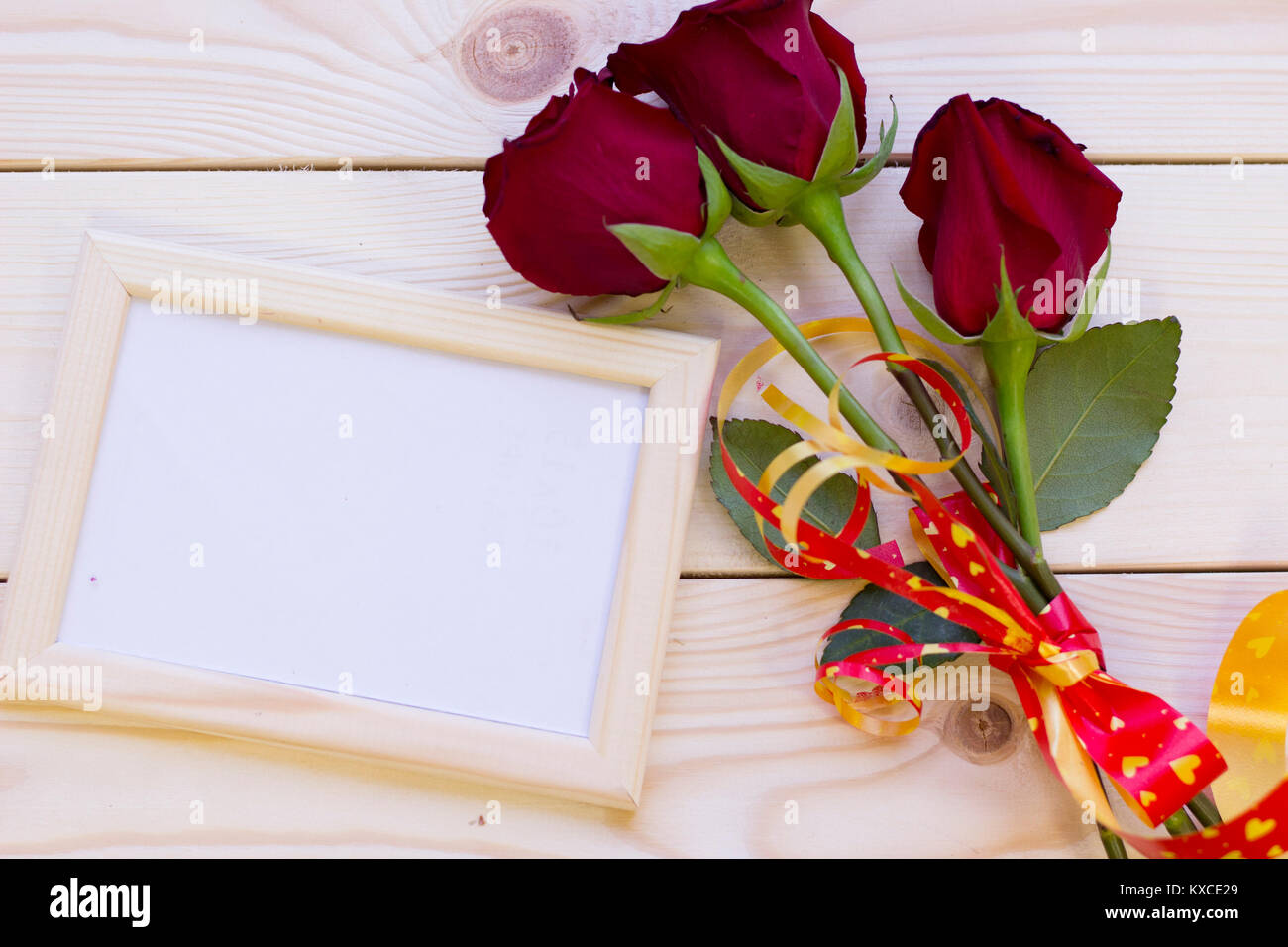 Red roses and photo frame Stock Photo - Alamy