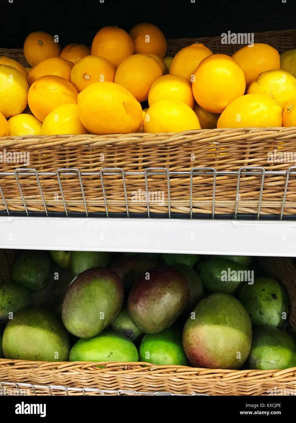Lemons and green mango in wicker baskets in supermarket Stock Photo - Alamy
