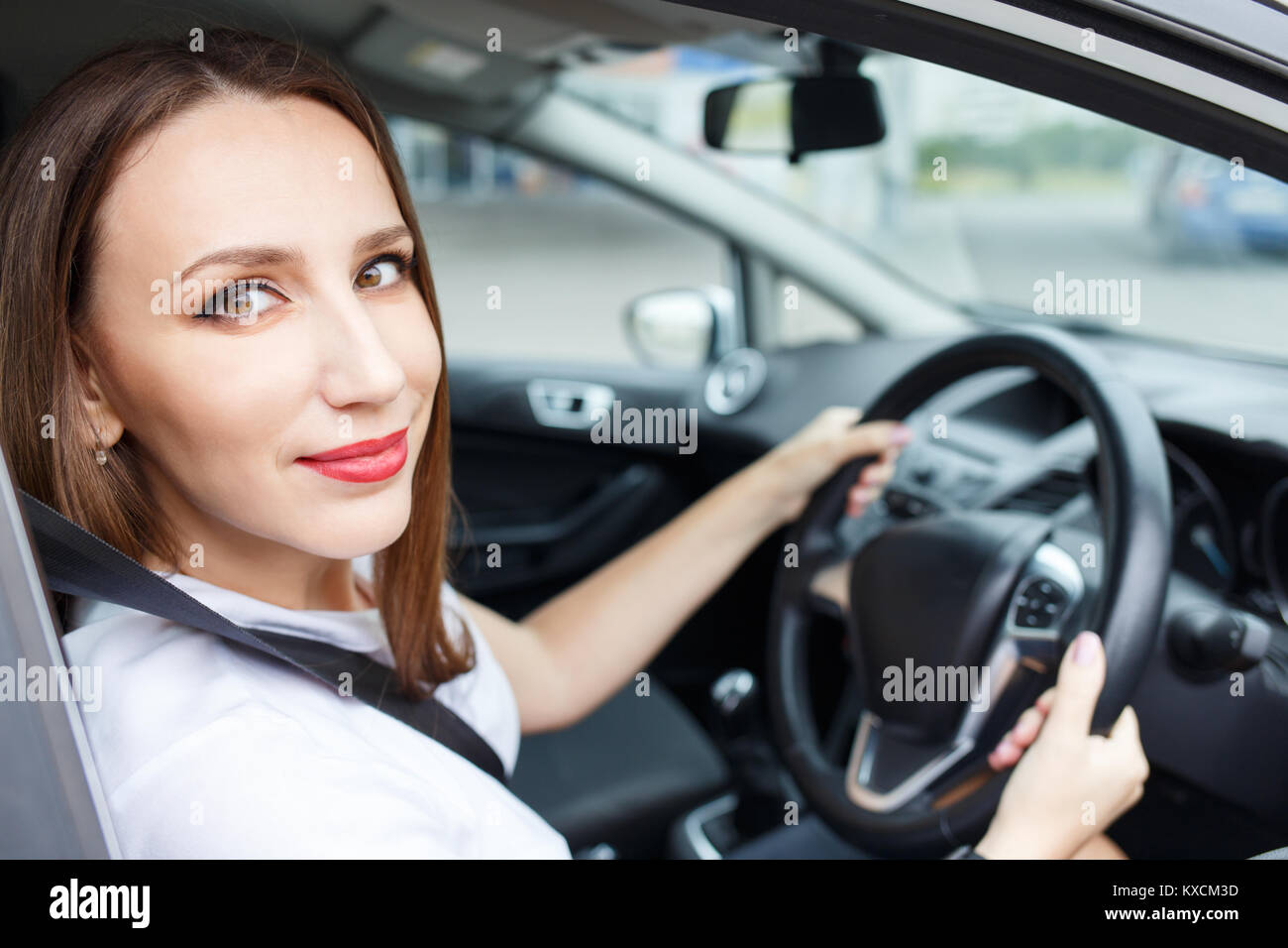 Young woman in white shirt driving car on the road. Hispanic girl ...