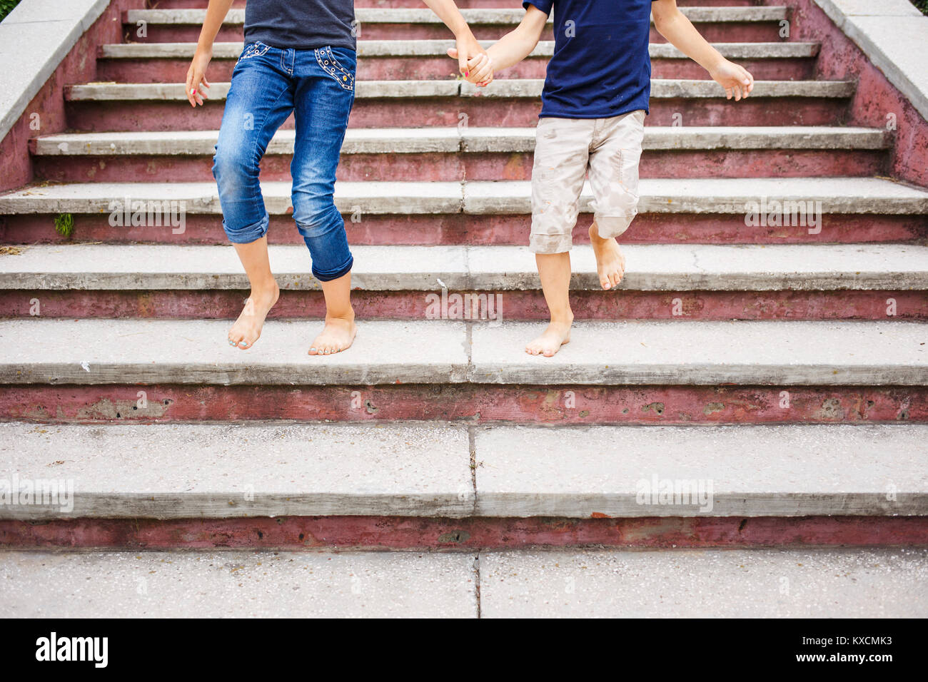 Children rushing down on stairs barefoot. Concept childhood image with ...
