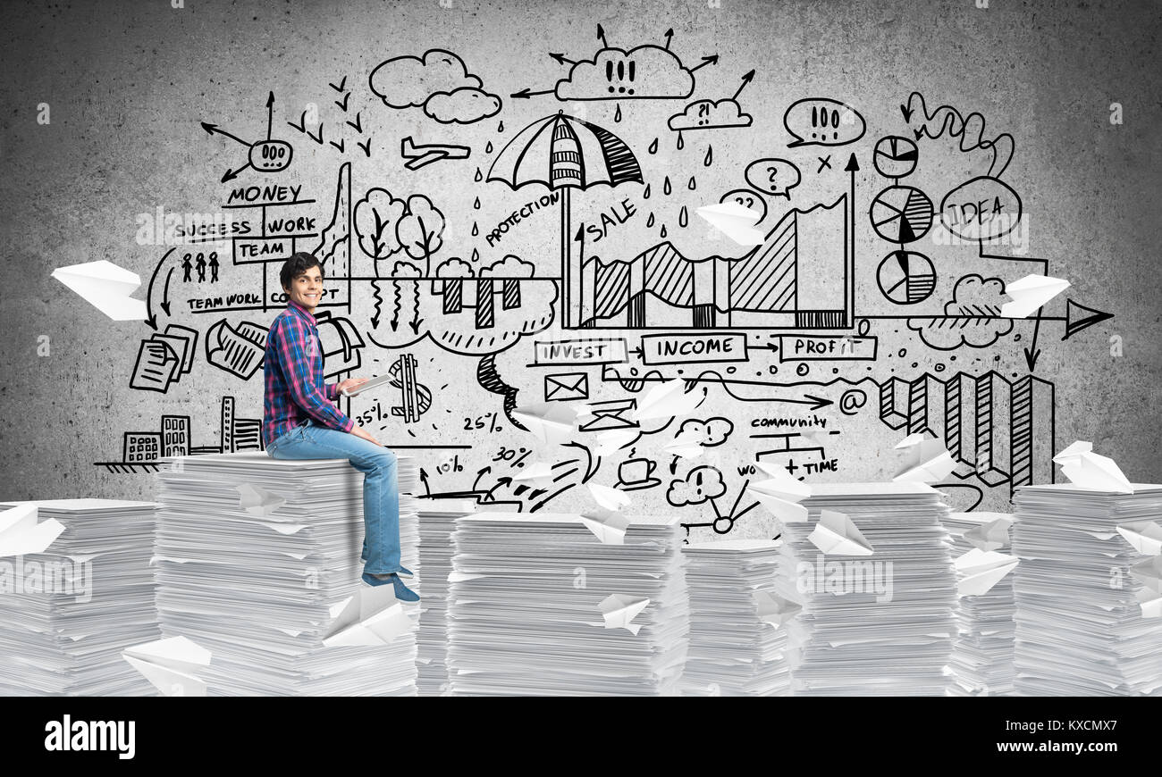 Attractive man sitting on pile of paper documents Stock Photo - Alamy