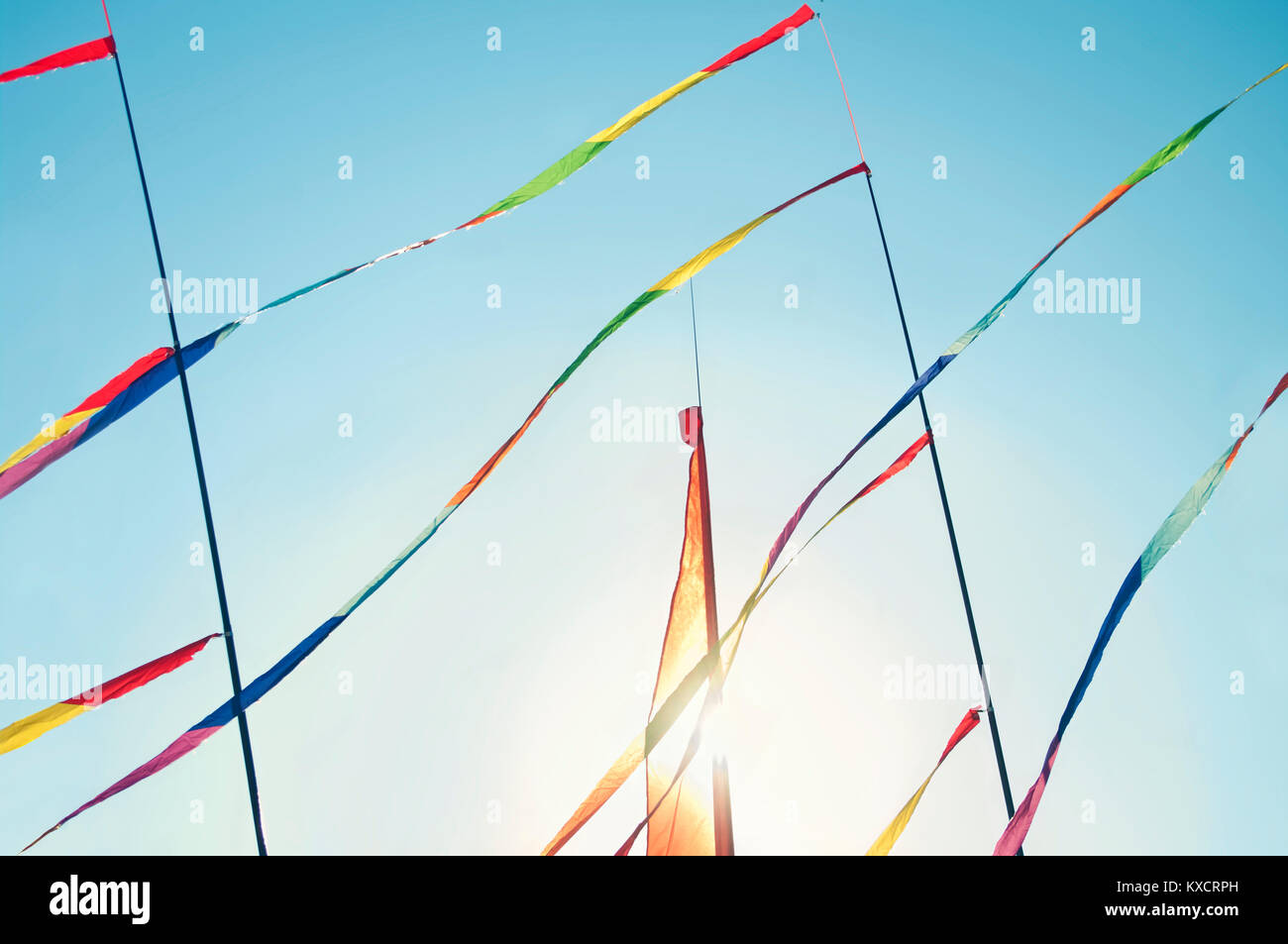 colorful strips of cloth tied to poles flying in wind on sunny spring ...