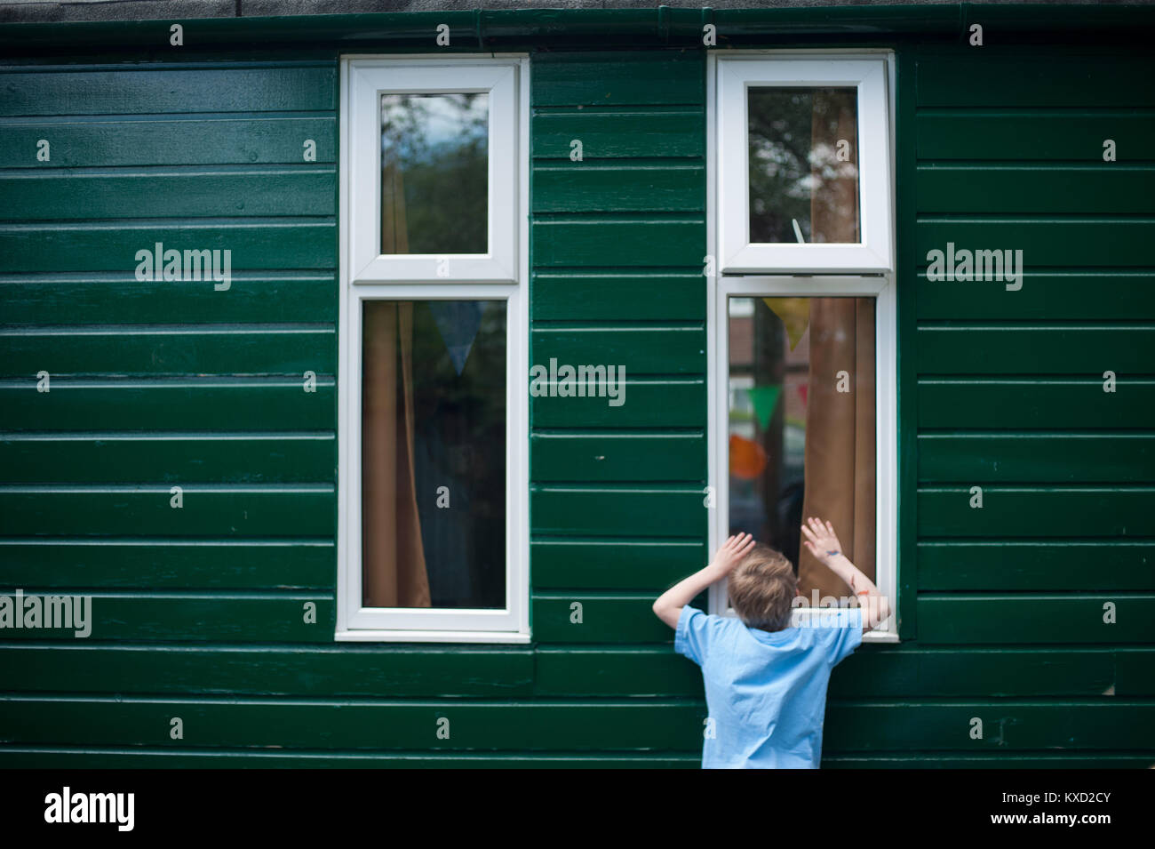 Child looks through window from outside Stock Photo - Alamy