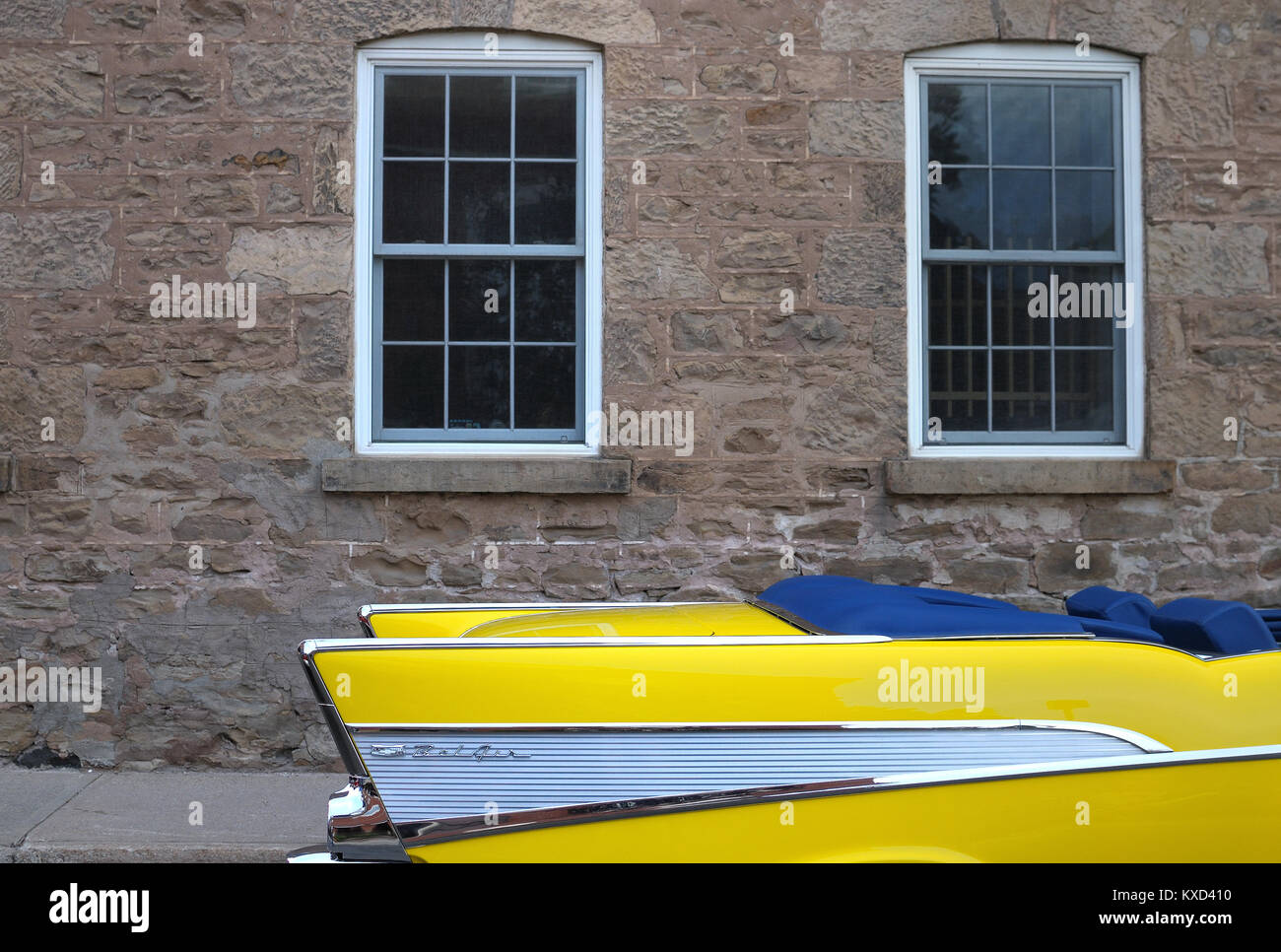 Rear tail fins on a bright yellow 1957 classic American convertable ...