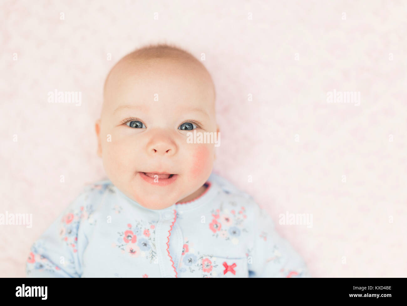 Overhead portrait of cute baby girl lying on bed Stock Photo - Alamy