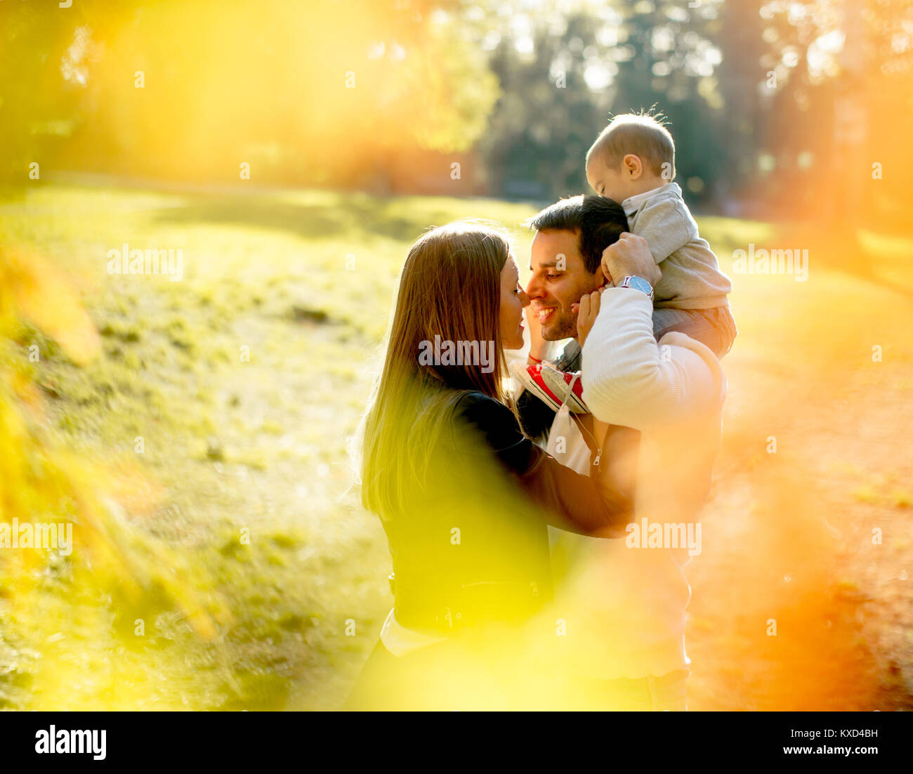Happy young parents have fun with baby boy in autumn park Stock Photo ...