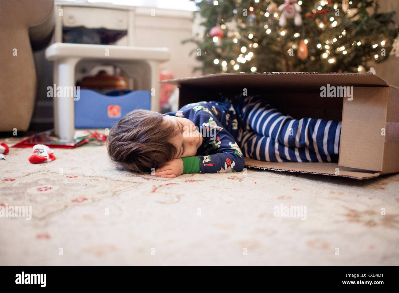 Boy sleeping in cardboard box at home during christmas Stock Photo - Alamy