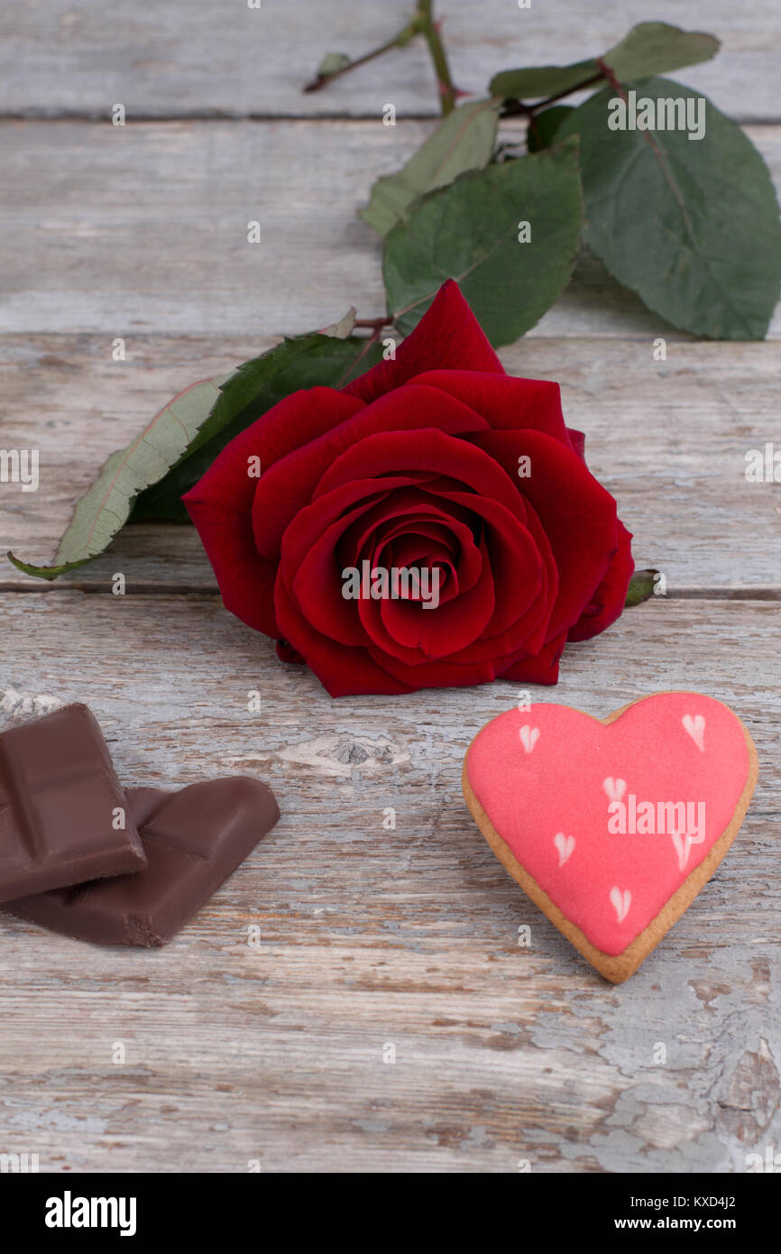 Red rose and sweets, wooden background Stock Photo - Alamy