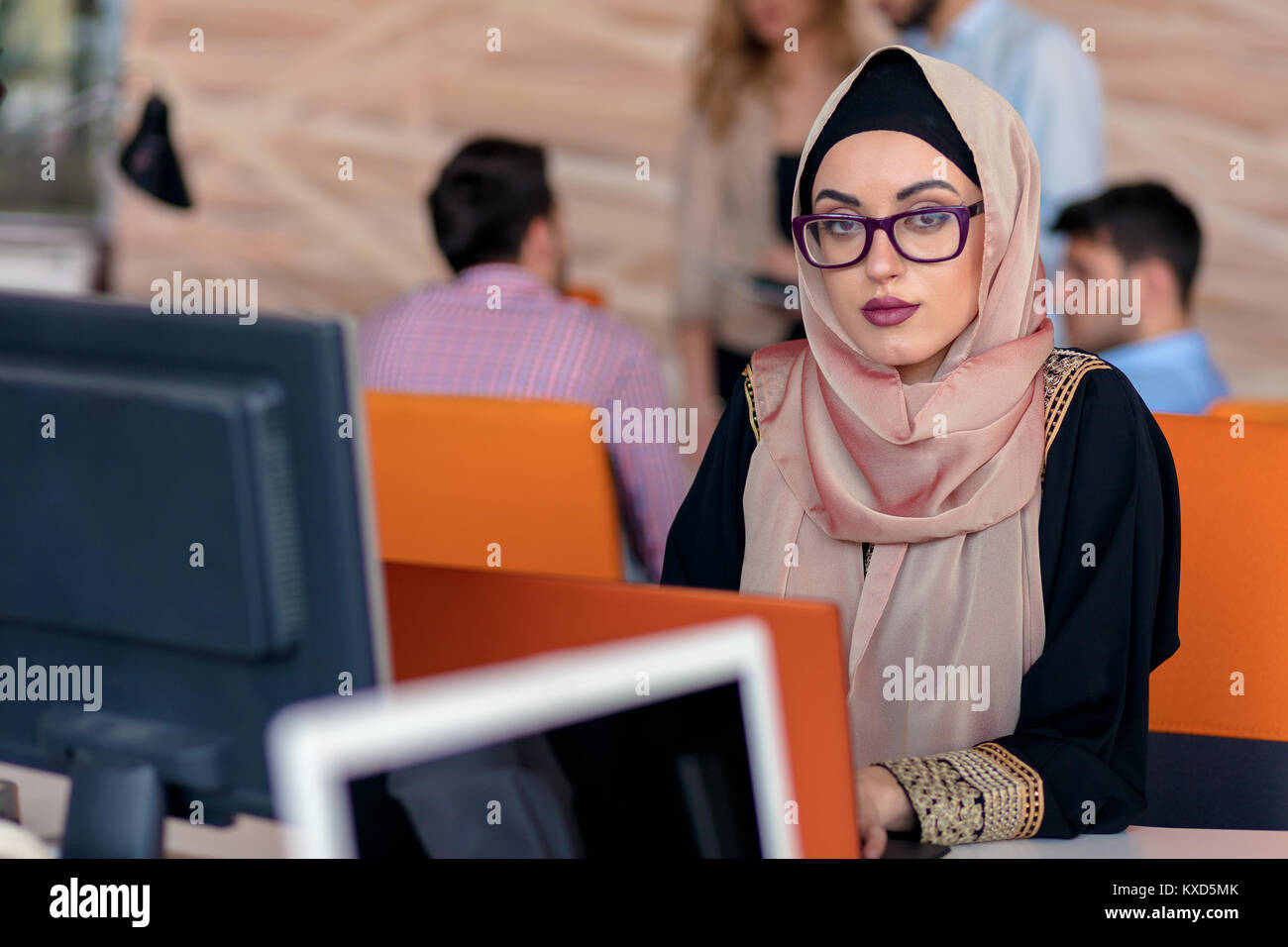 Attractive Muslim young woman working in office on computer Stock Photo ...