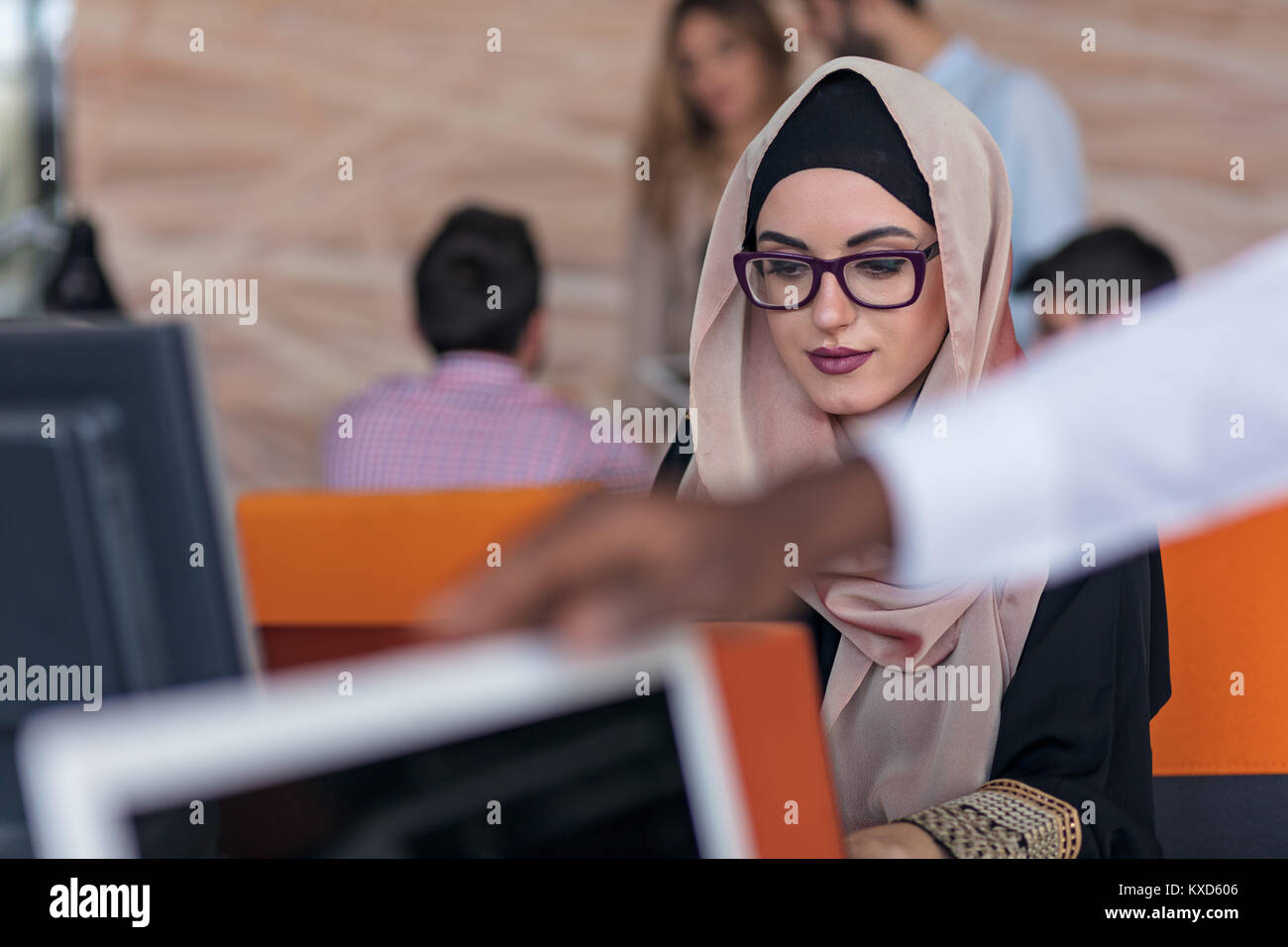 Attractive Muslim young woman working in office on computer Stock Photo ...