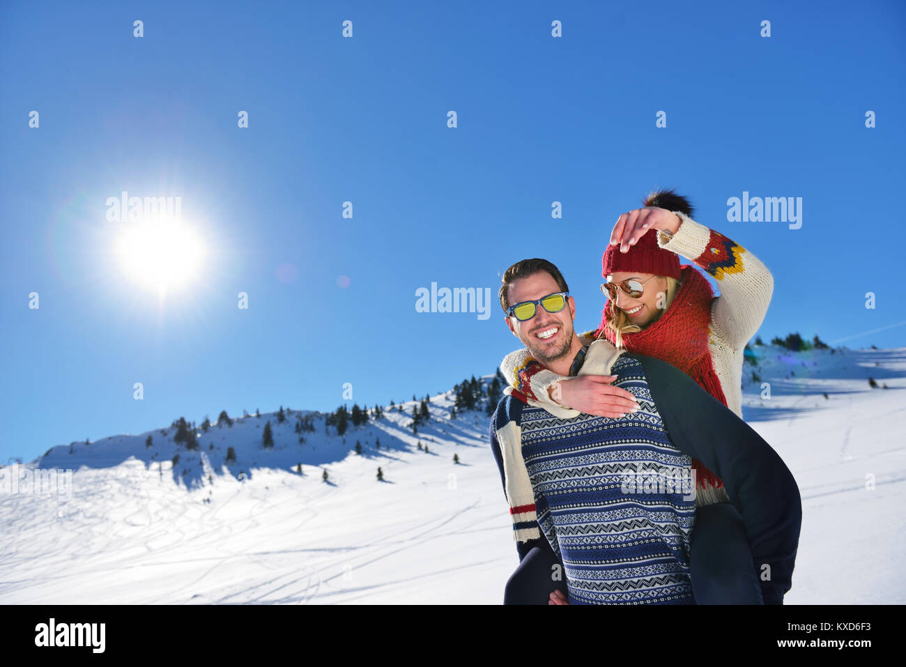 Young couple having fun on snow. Happy man at the mountain giving ...