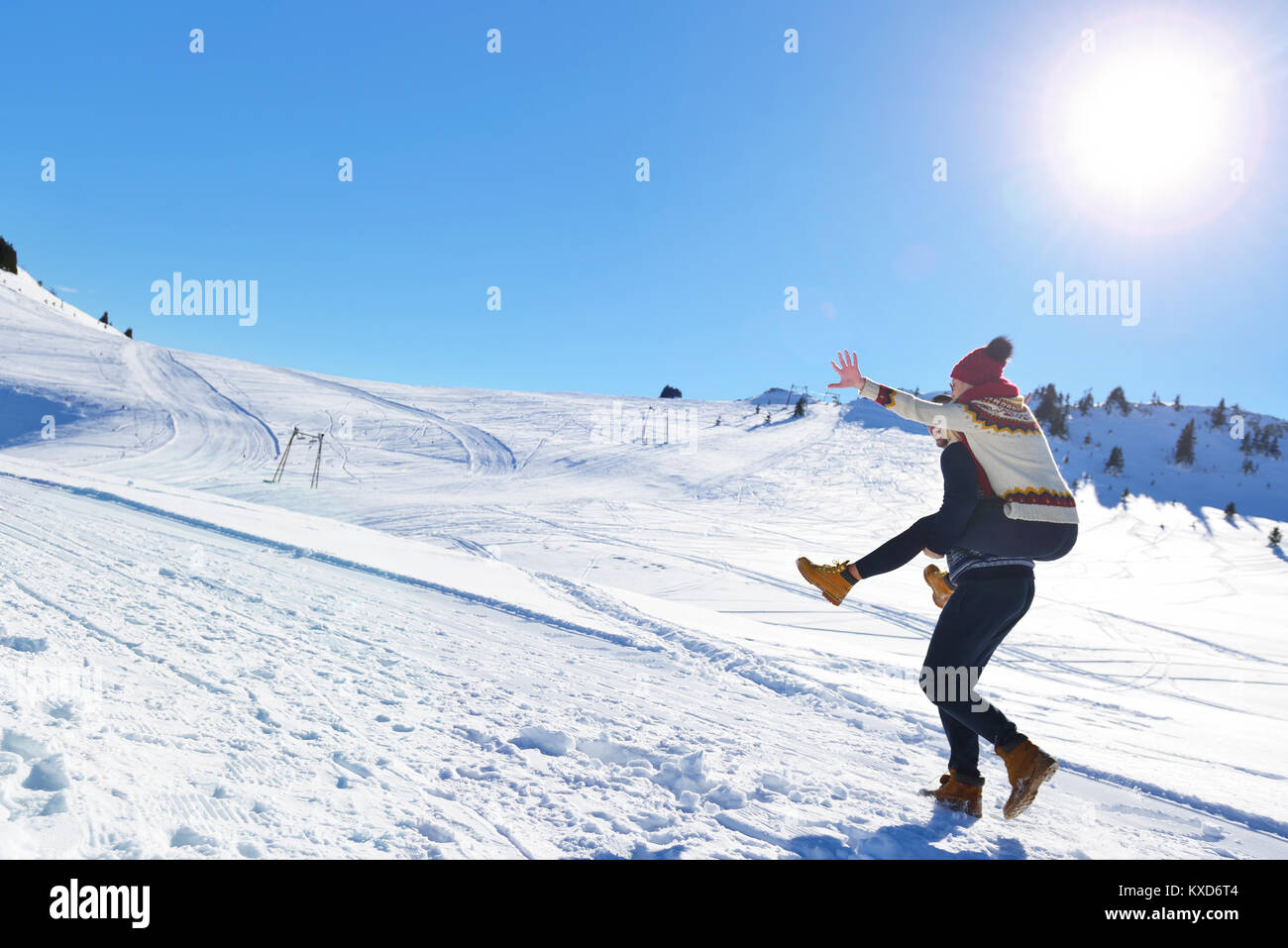 Young couple having fun on snow. Happy man at the mountain giving ...